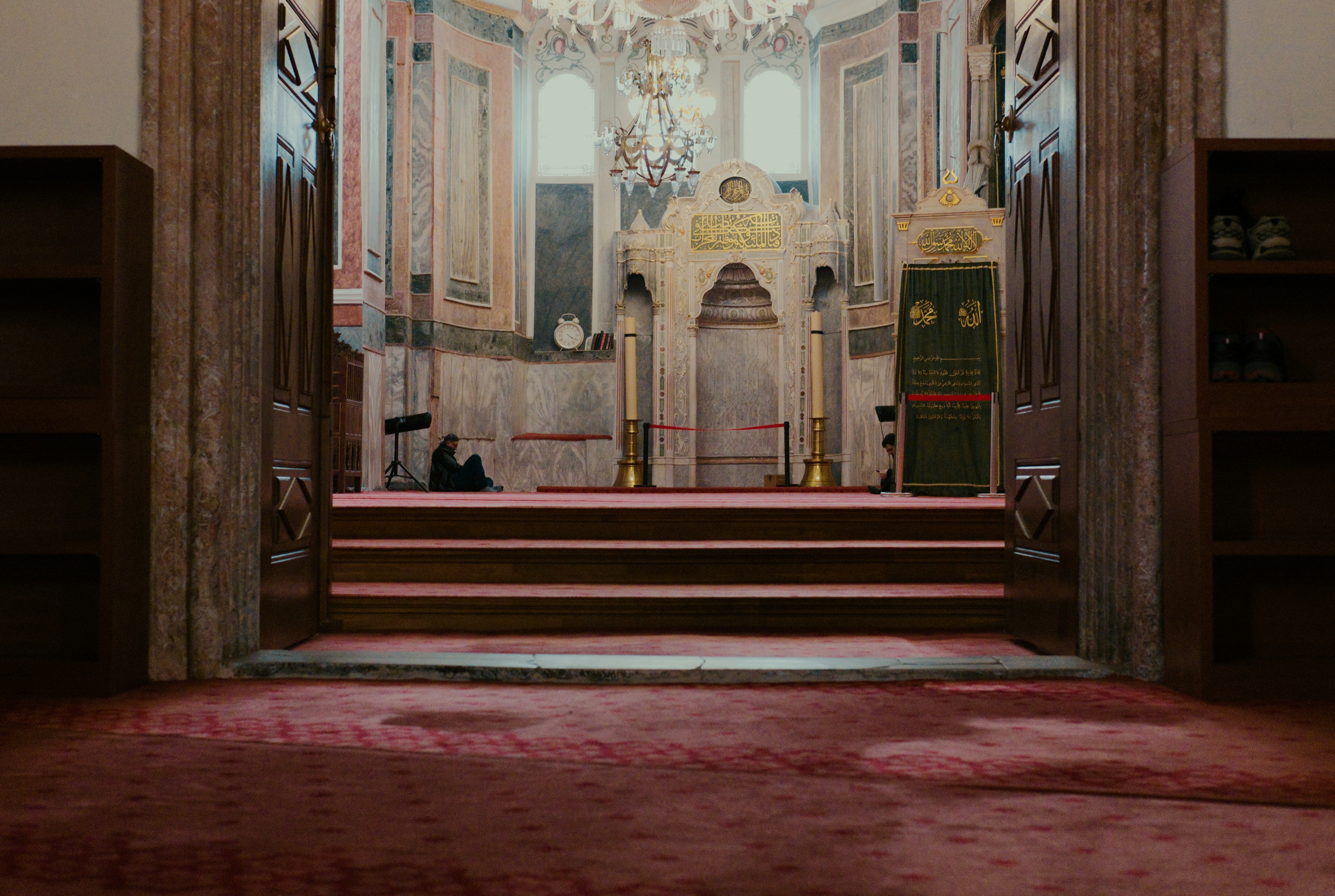 Ornate interior of a mosque with intricate arches and soft lighting.