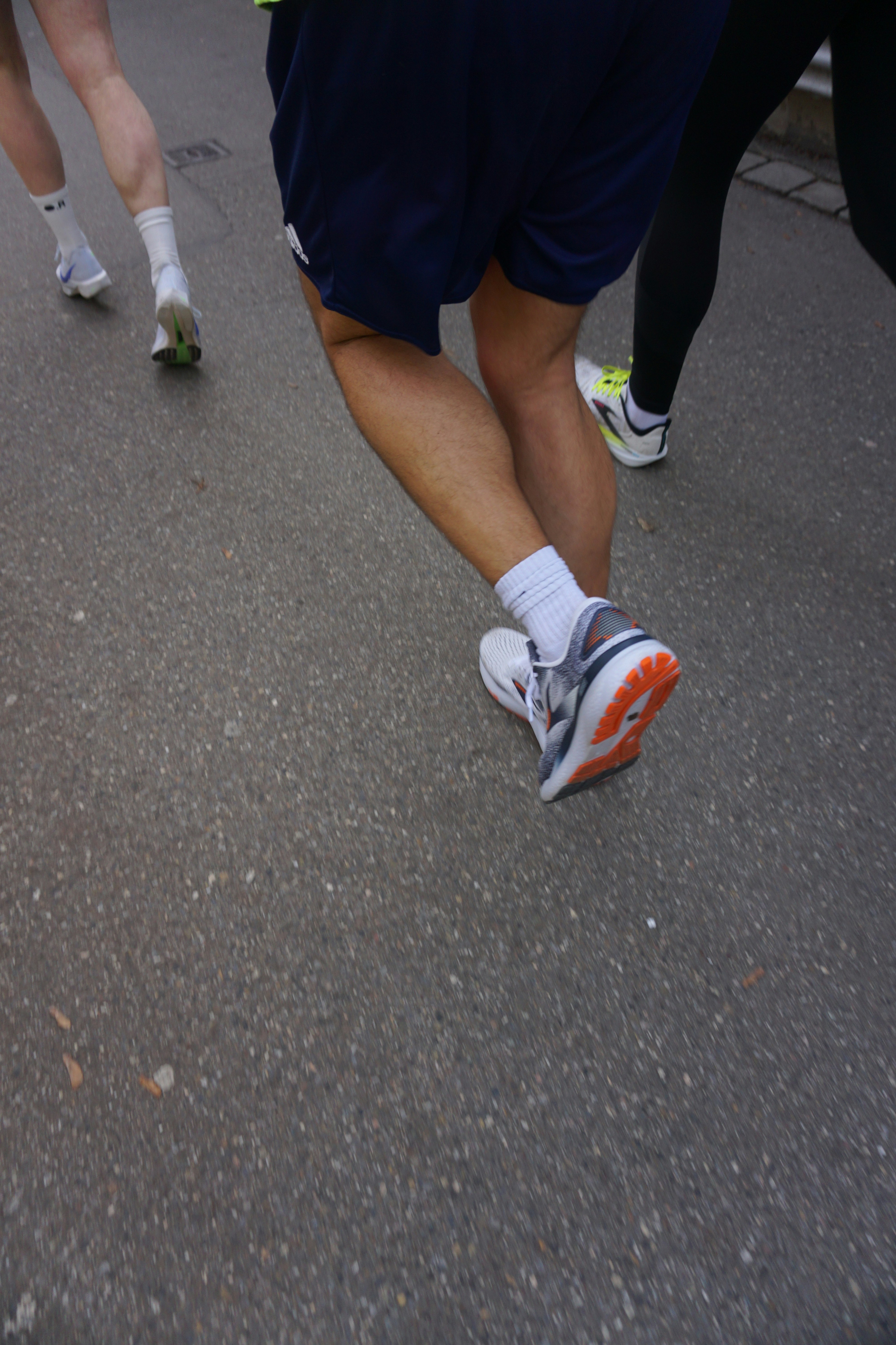 Mid-race cadence: close-up on muscular legs and worn running shoes