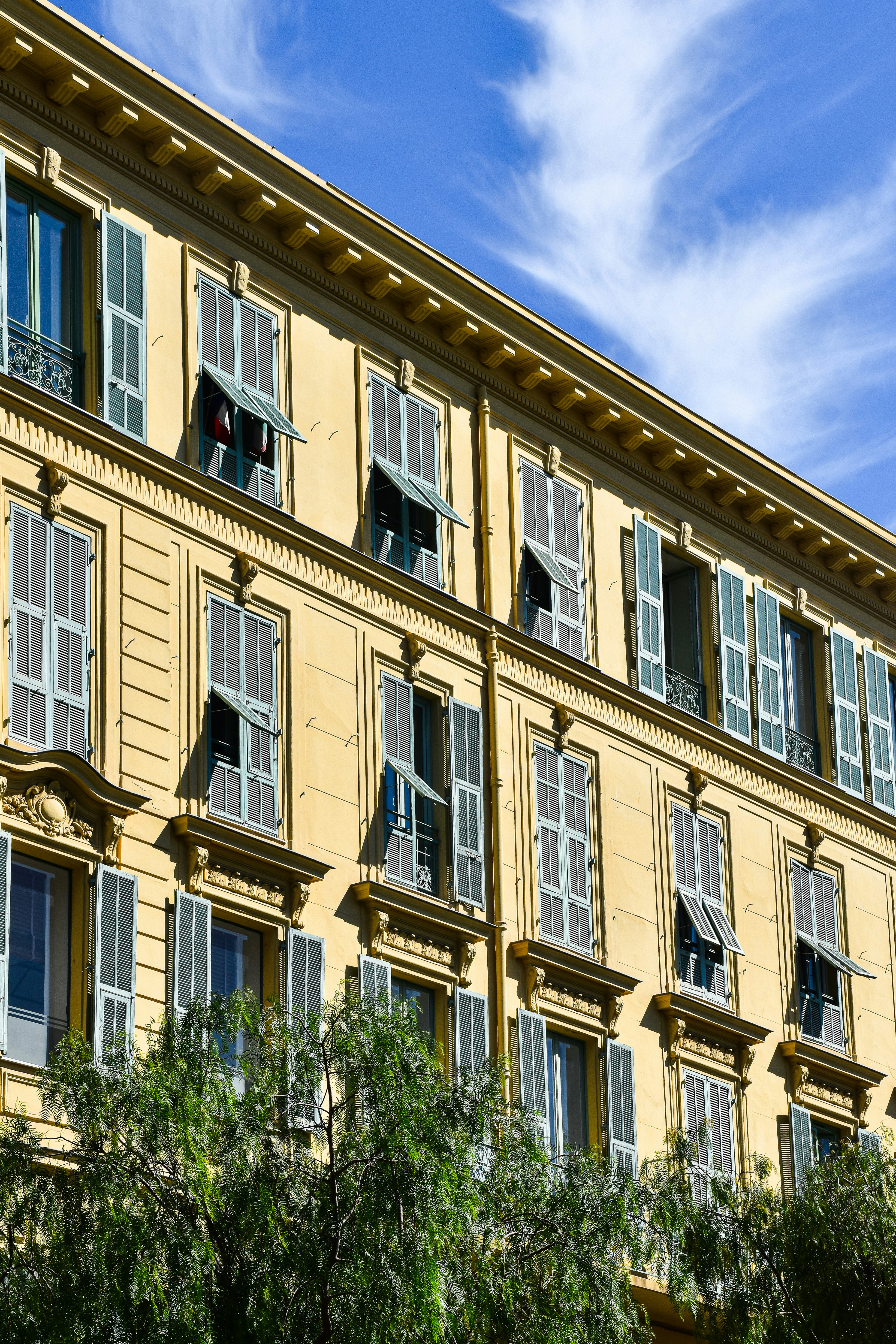 A tall yellow building with lots of windows photo – Free Travel Image ...