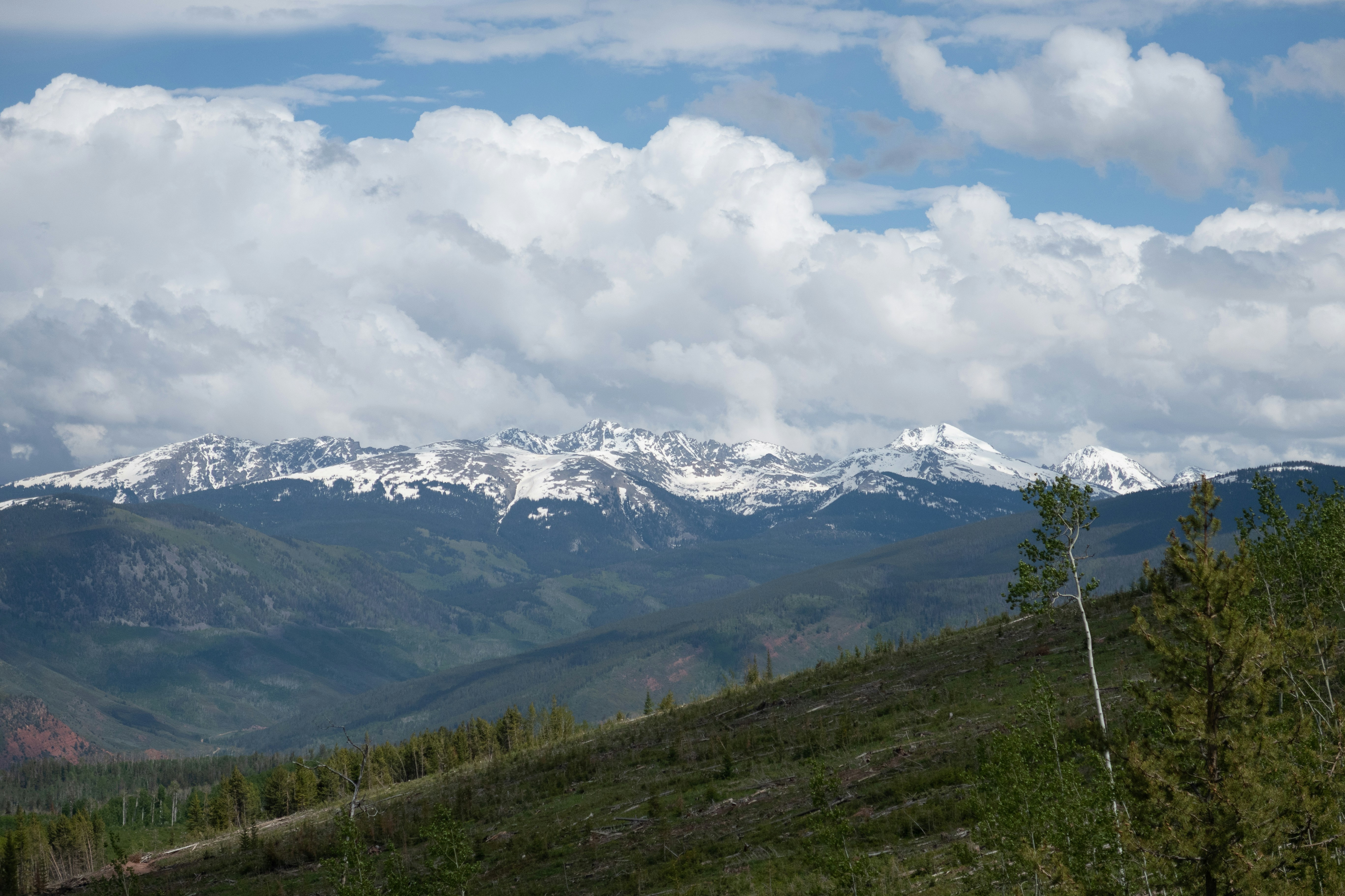 Snow-capped peaks of the New York Range under a sky filled with dramatic clouds.