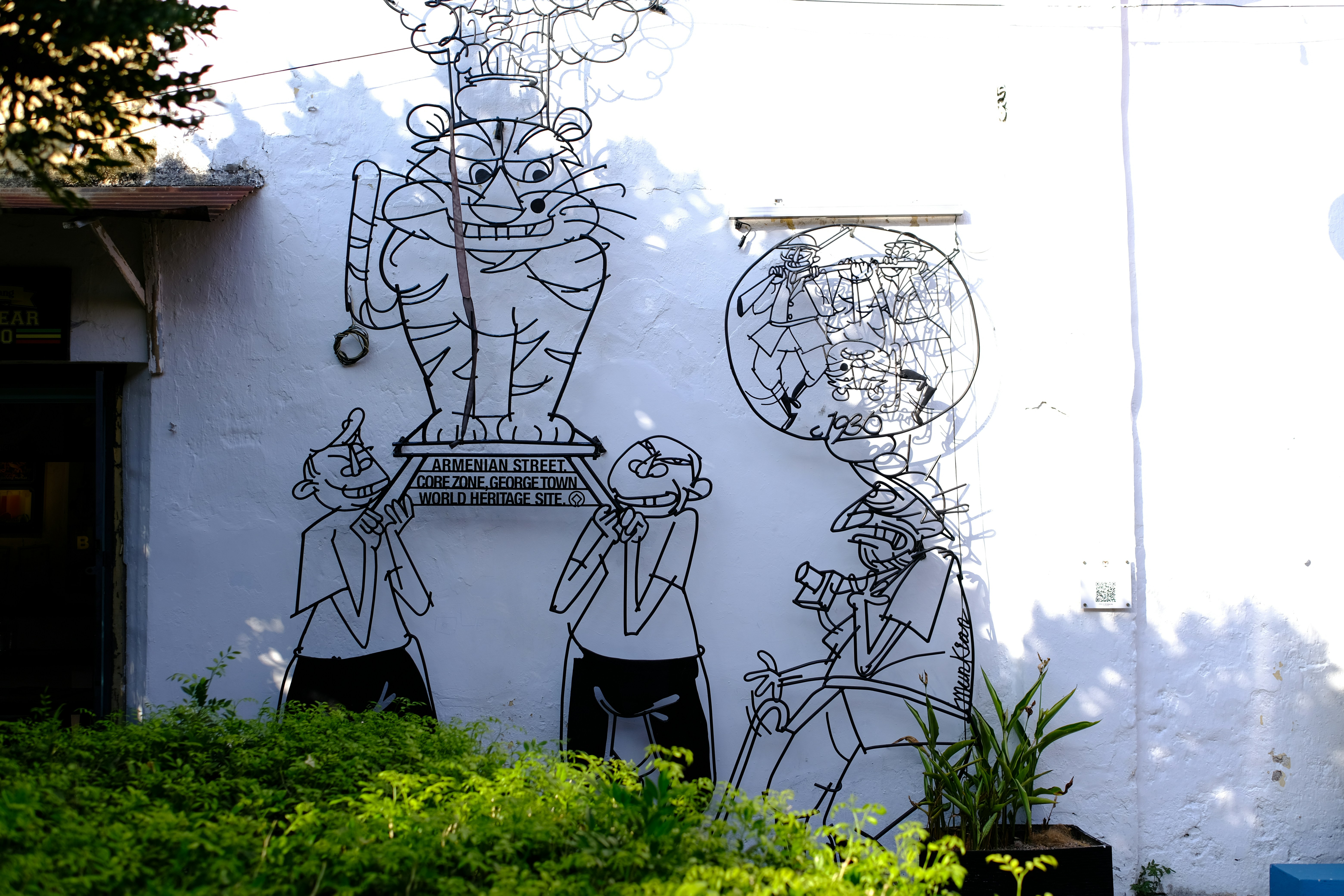 Colossal Line Art: Giants on a White Wall Framed by Greenery