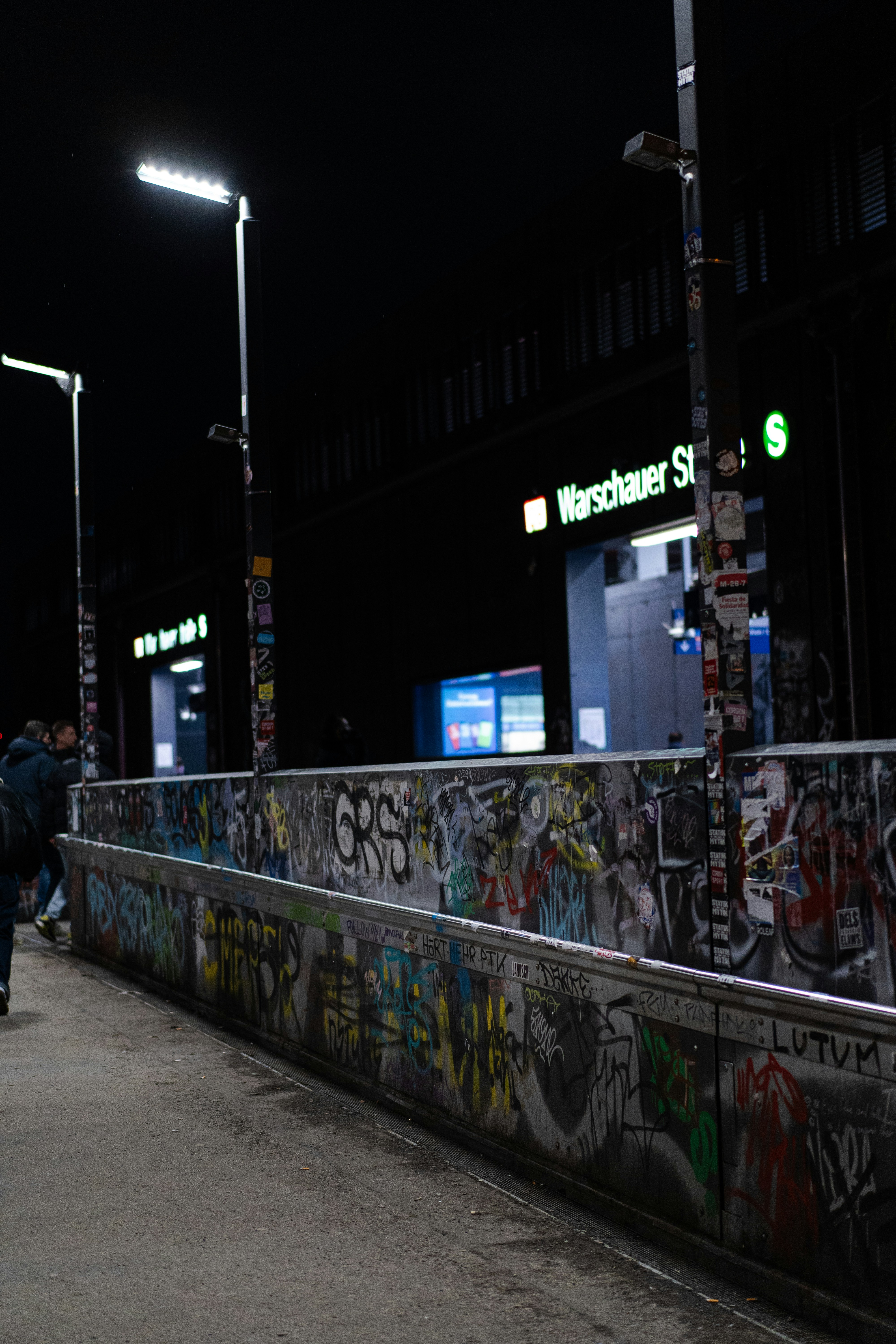 Warschauer Street Night: Graffiti-Scrawled Railings Lead to a Luminous Subway Entrance