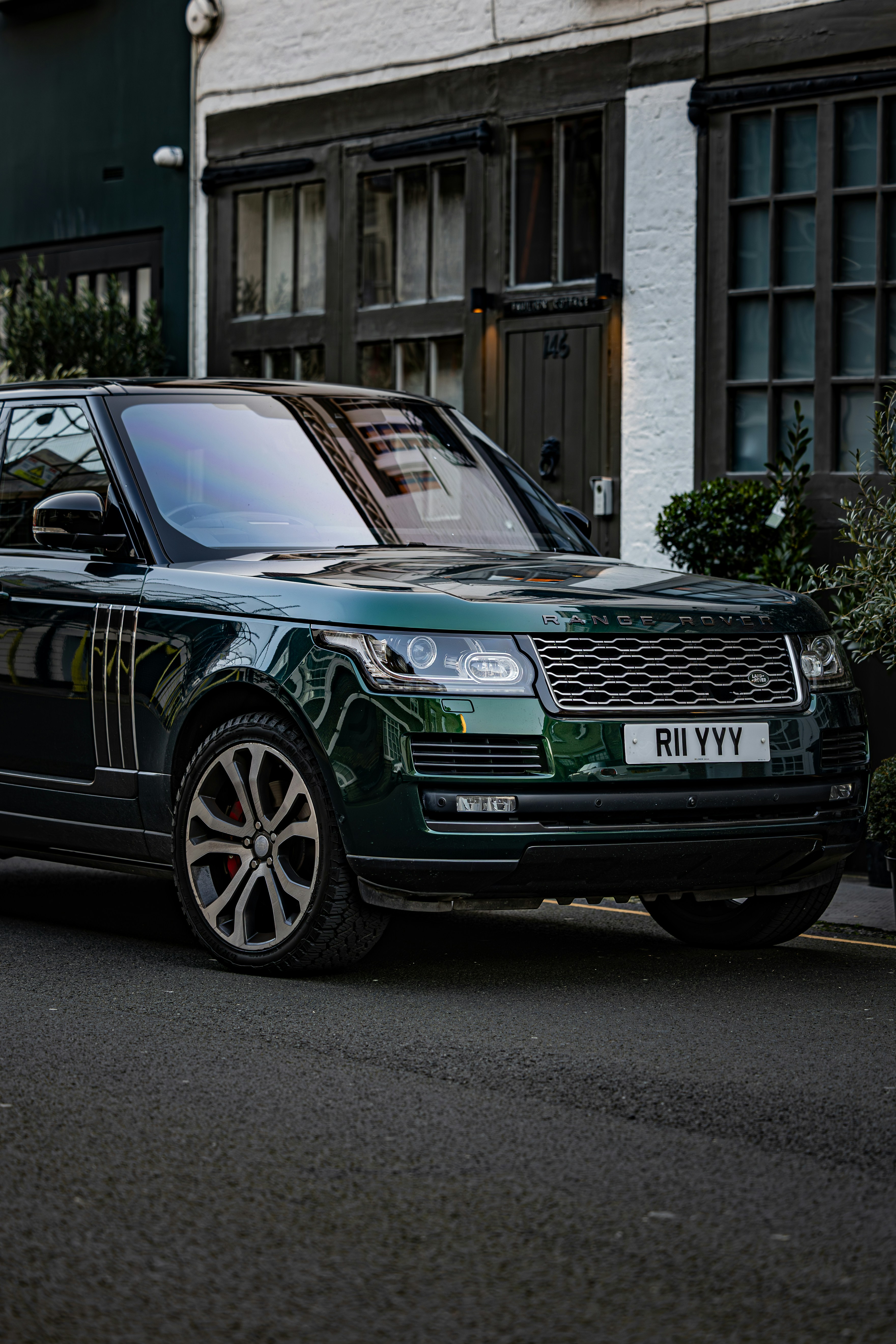 A green range rover parked on the side of the road photo – Free Street ...