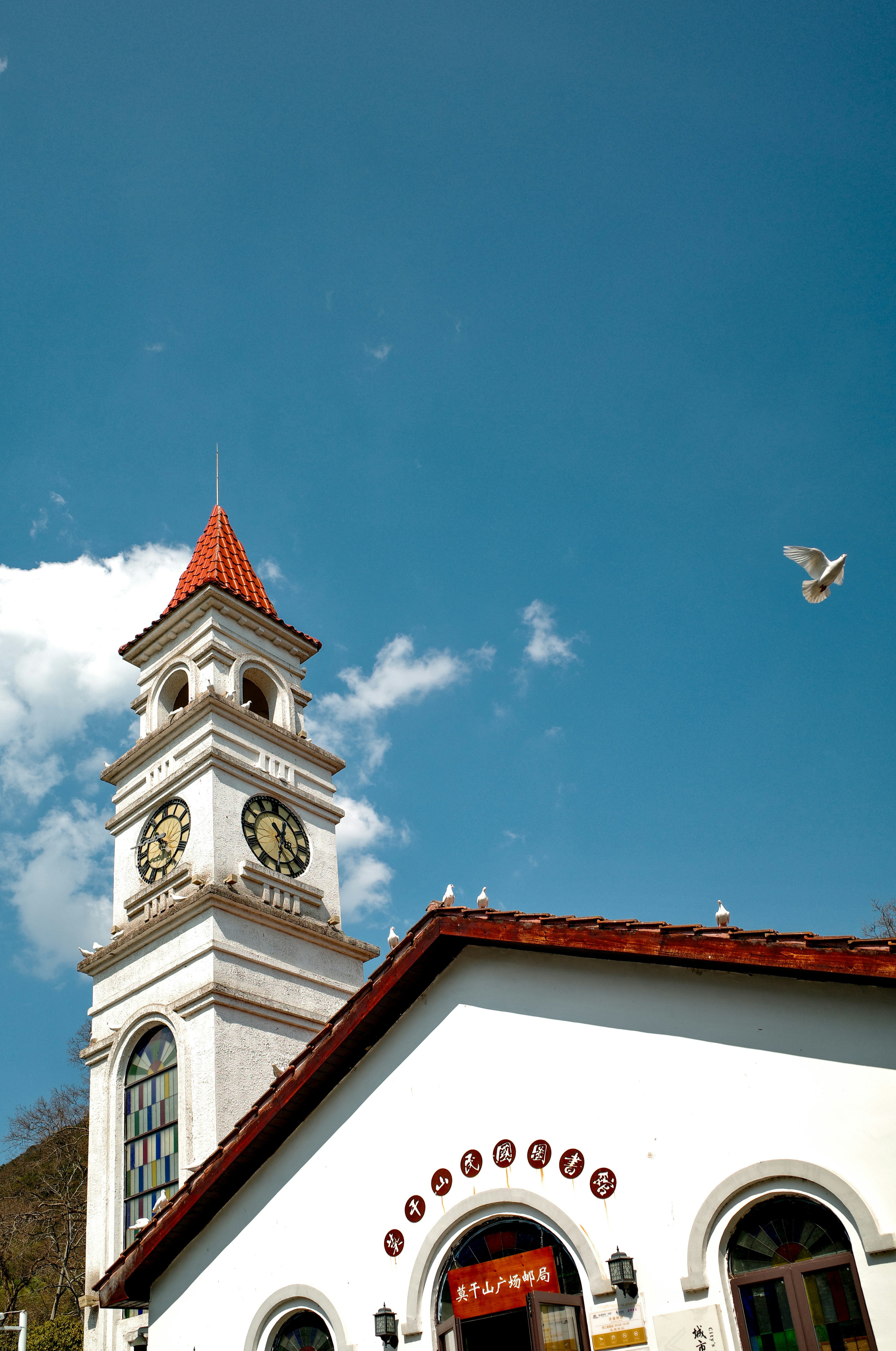 Clock tower with a red roof under a blue sky.monk 333