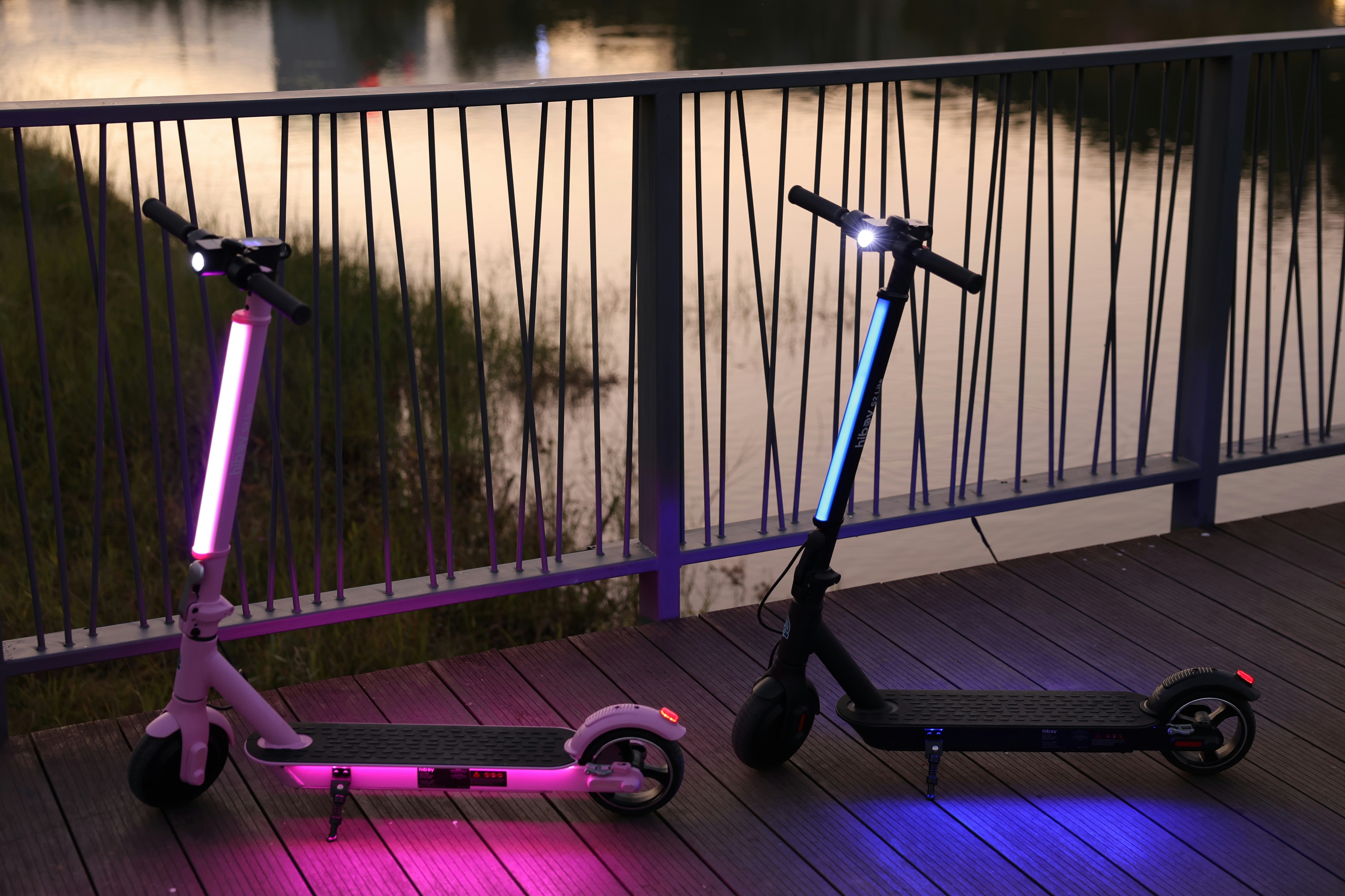 Twin Neon Scooters by the Riverside Rail