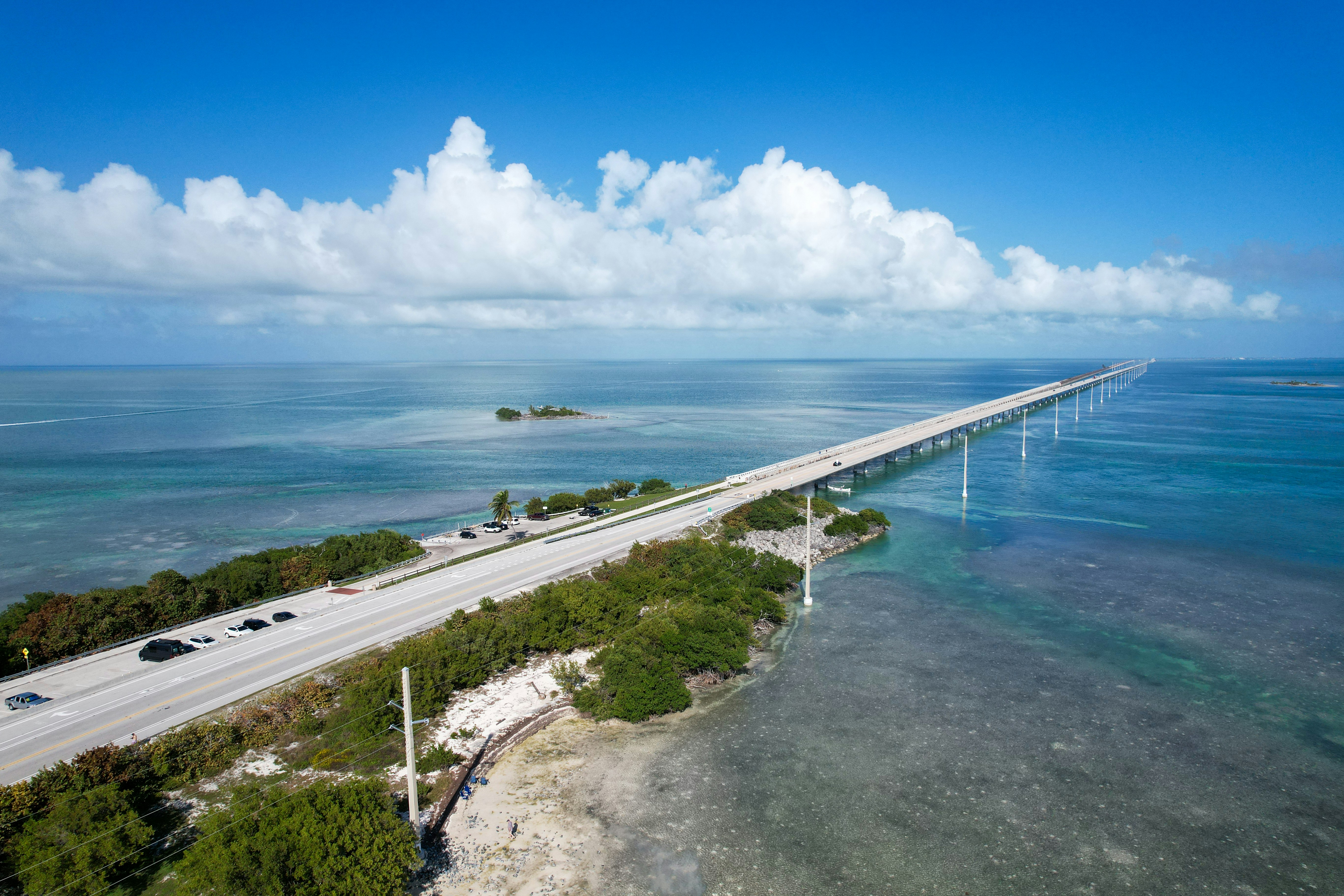 Aerial view of the Seven Mile Bridge stretching across turquoise seas under a vibrant blue sky.