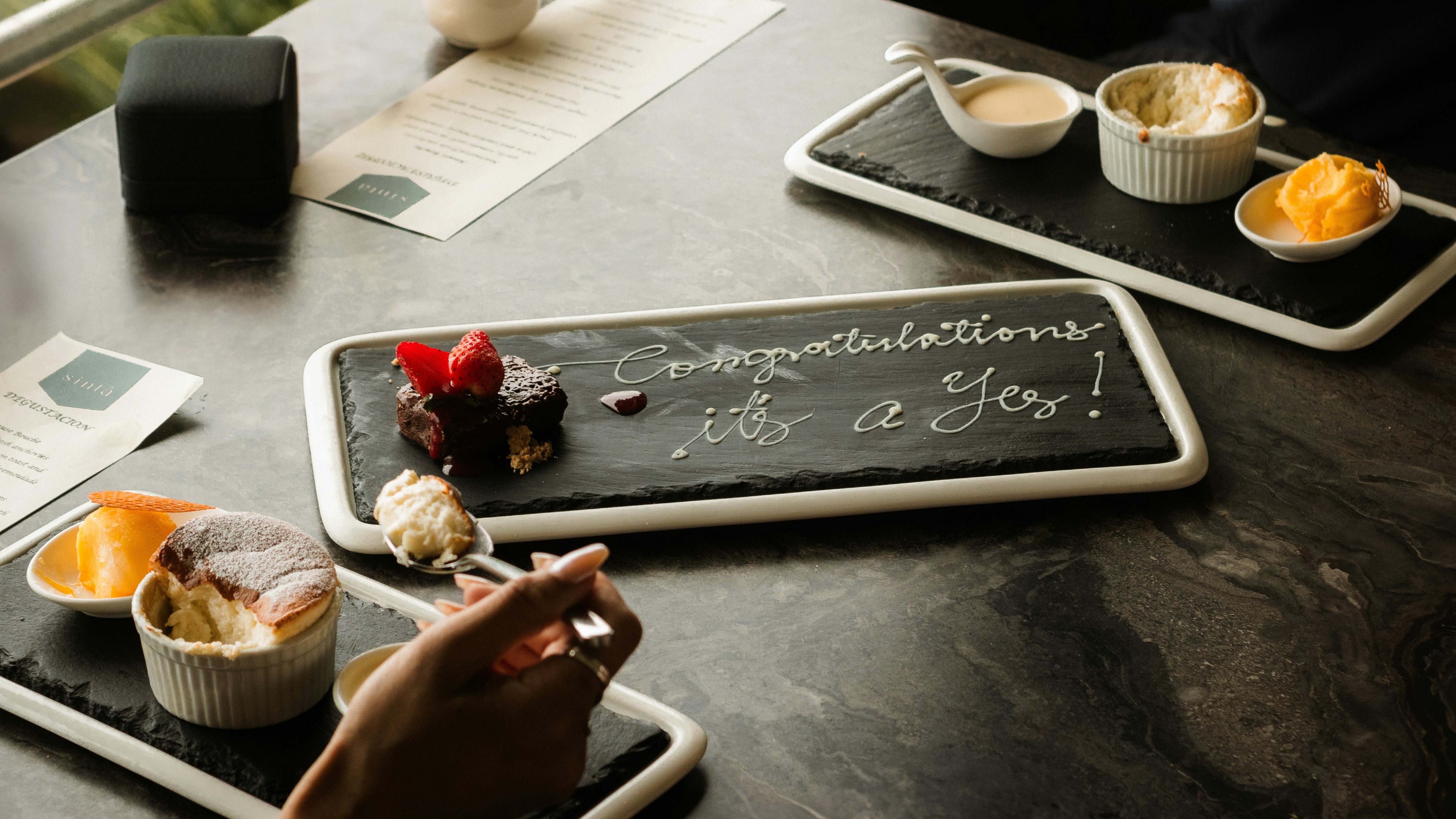 Chalkboard Congratulations Amid a Café Dessert Spread