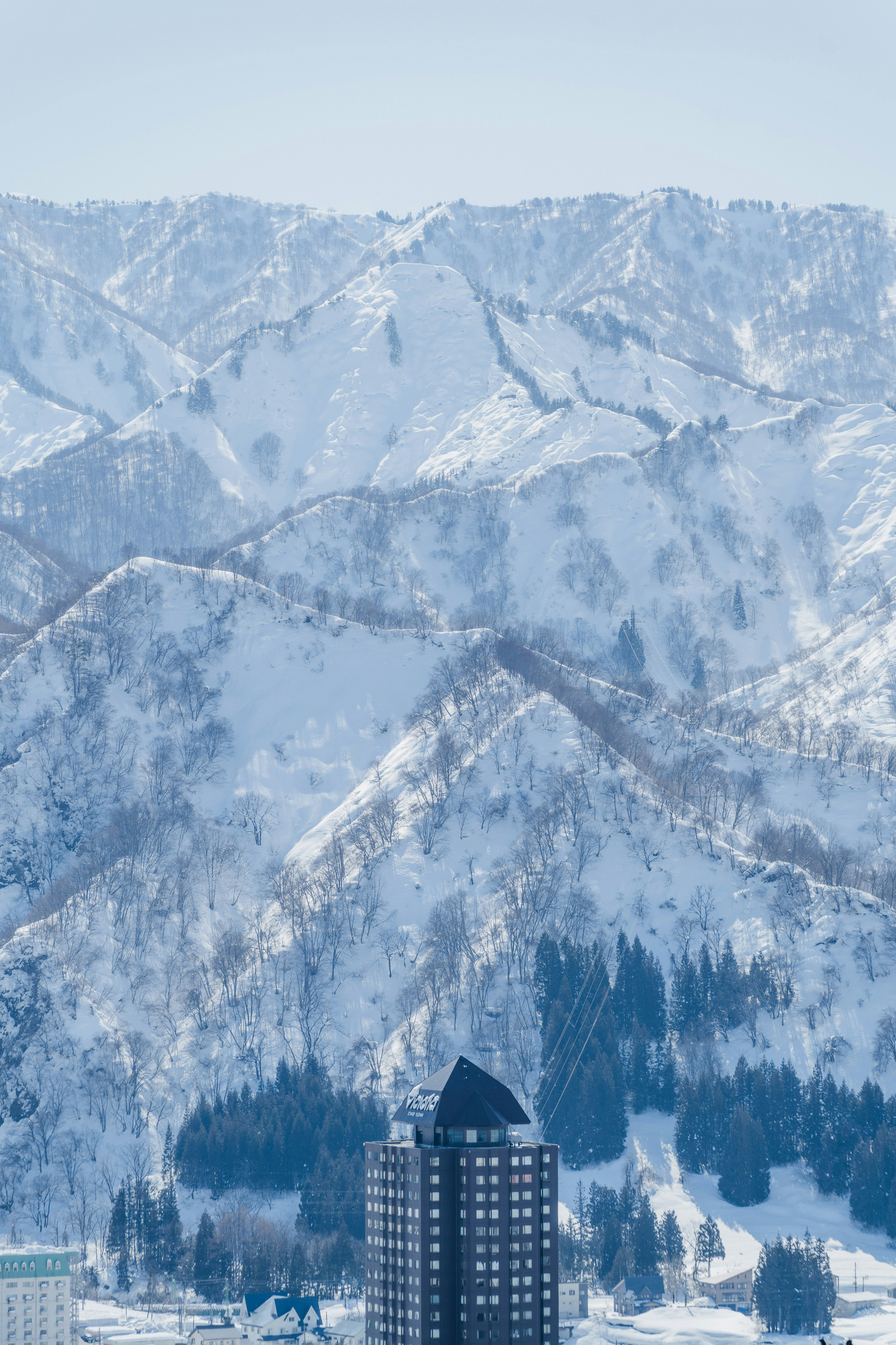 Snowy mountains tower over a city building. photo – Free Building Image ...