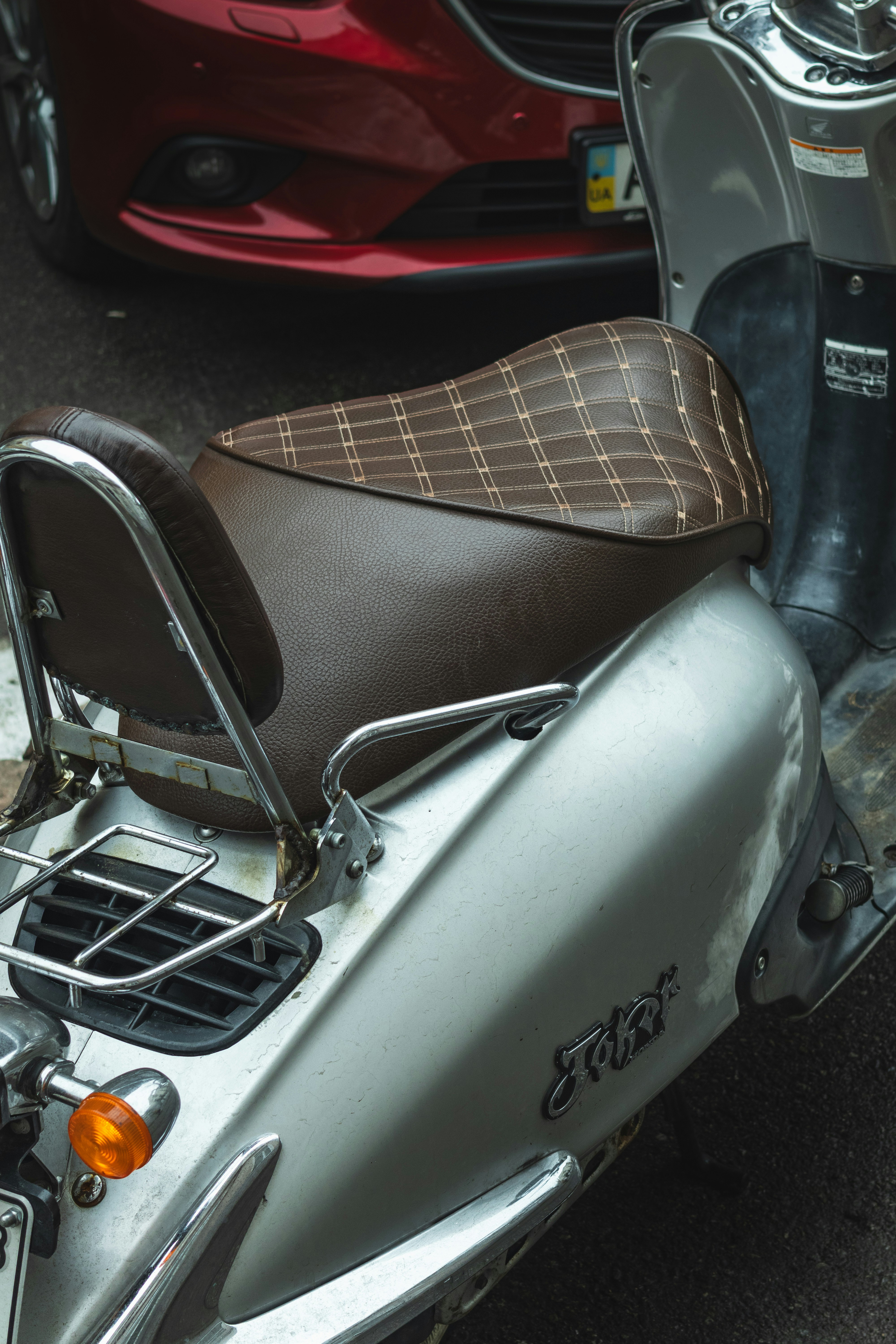 A close-up of a silver scooter's seat.