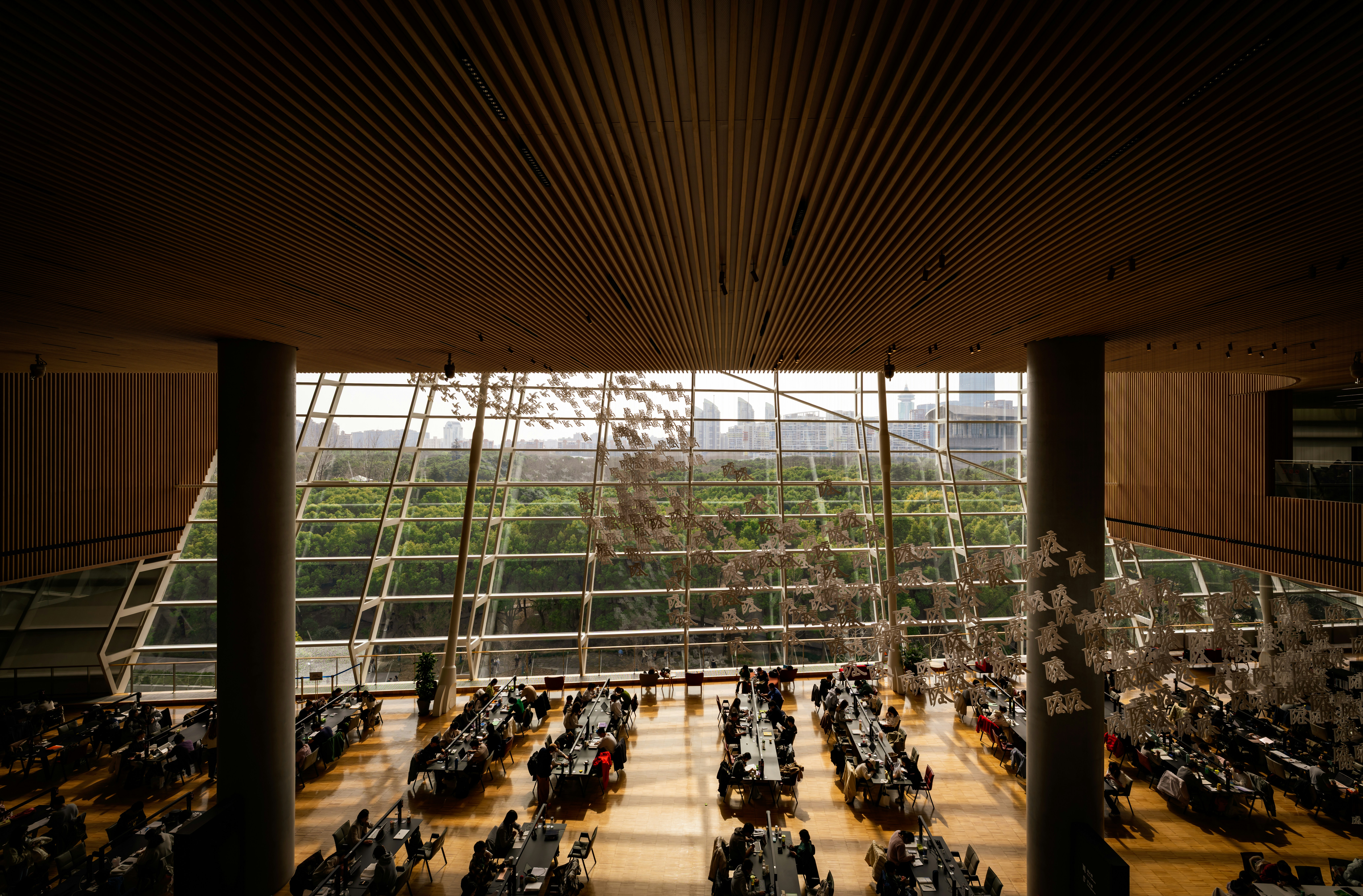 Spacious interior with large glass windows revealing a lush green landscape and distant city skyline.