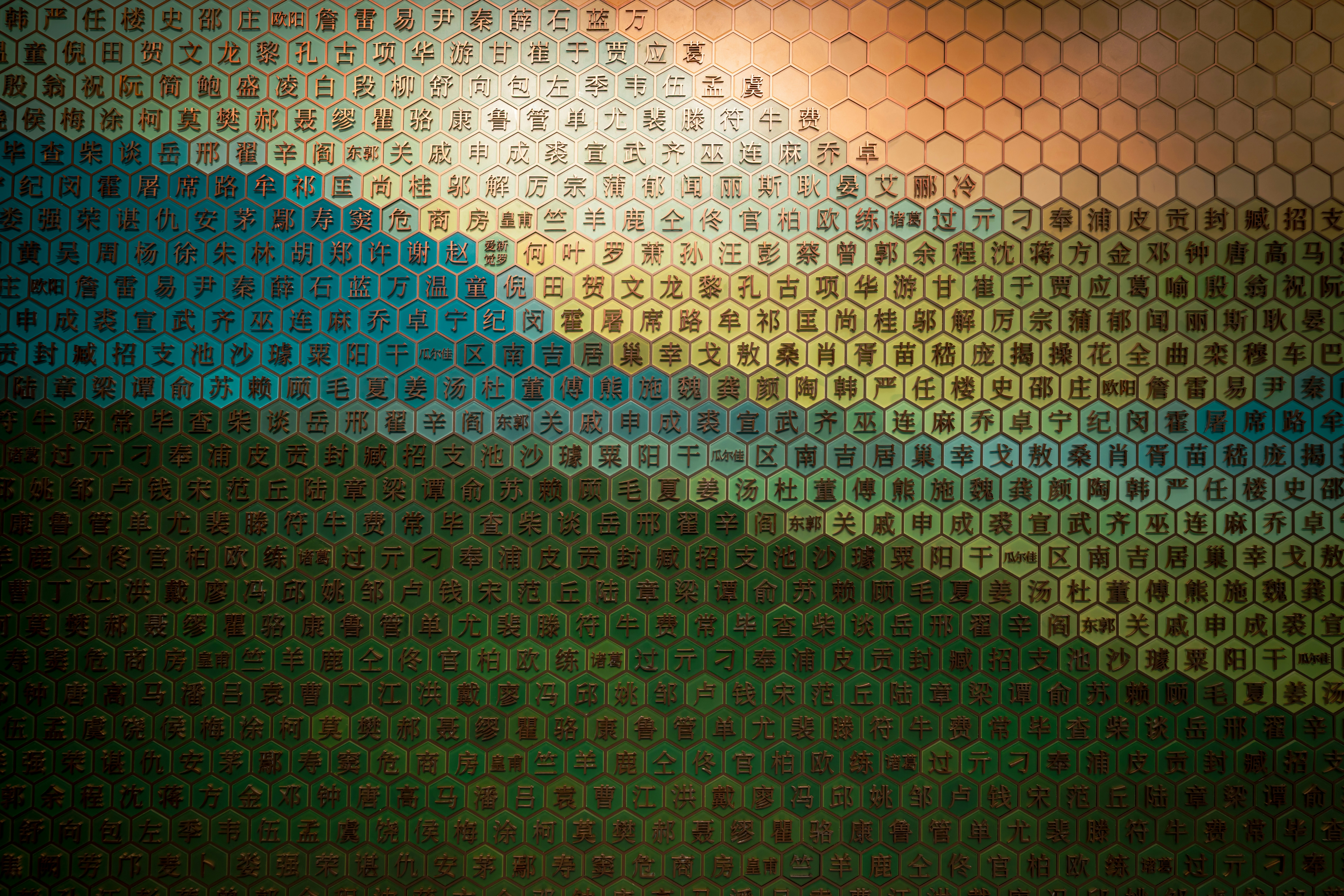Colorful hexagonal tiles with intricate Chinese characters create a gradient pattern.