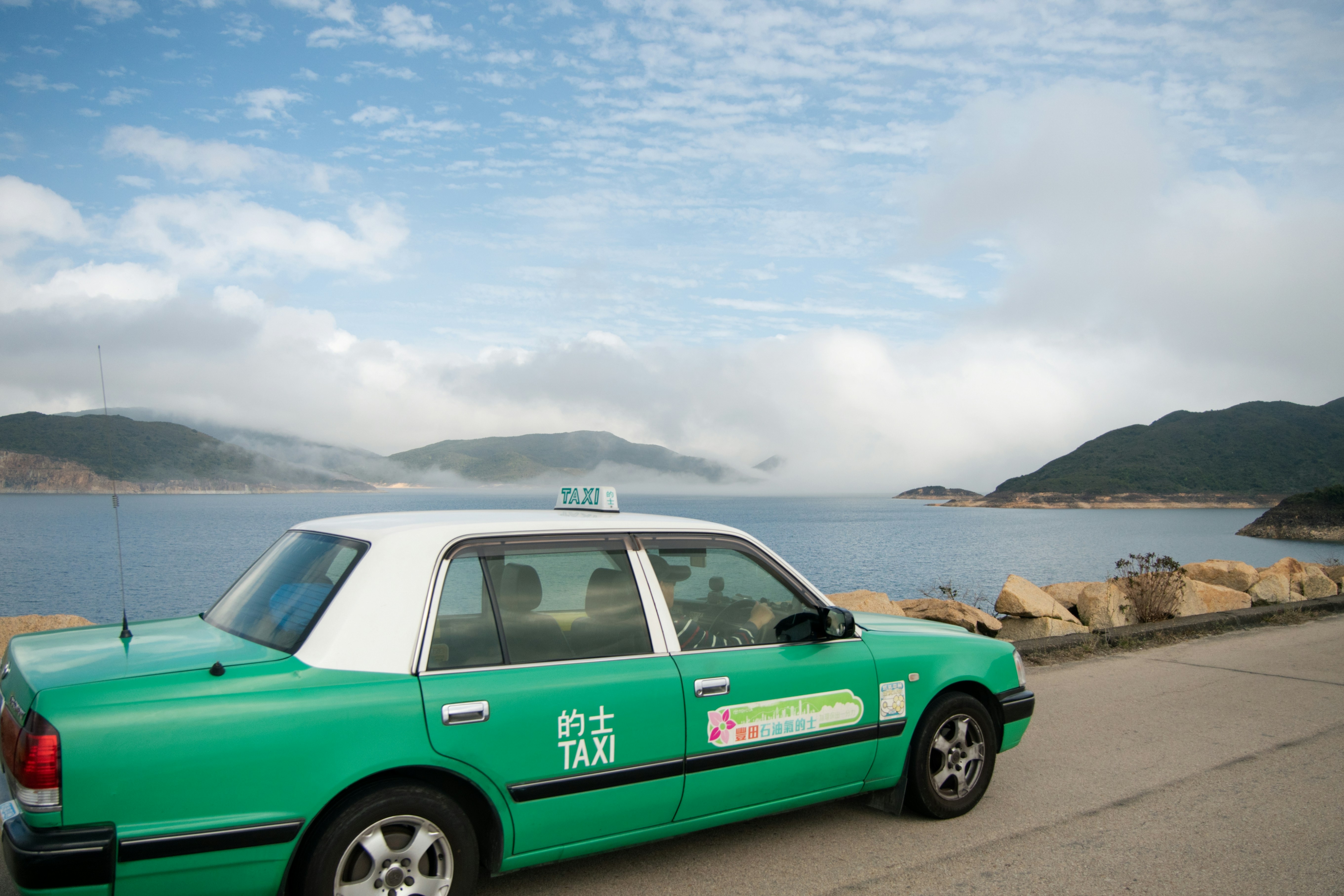 A green taxi is parked near a beautiful shoreline. photo – Free Car ...