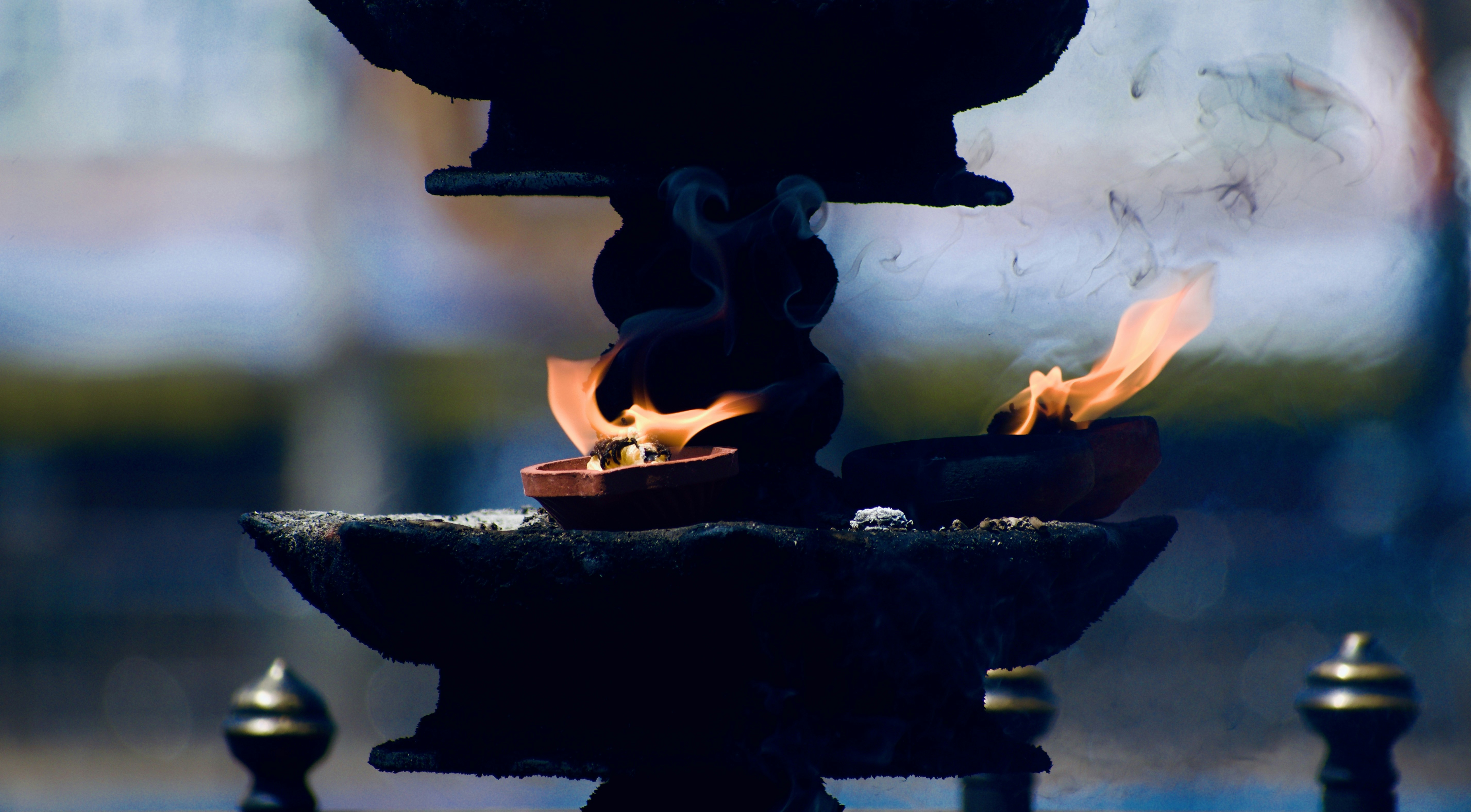 Burning lamps are lit in a religious setting. photo – Free Man Image on ...