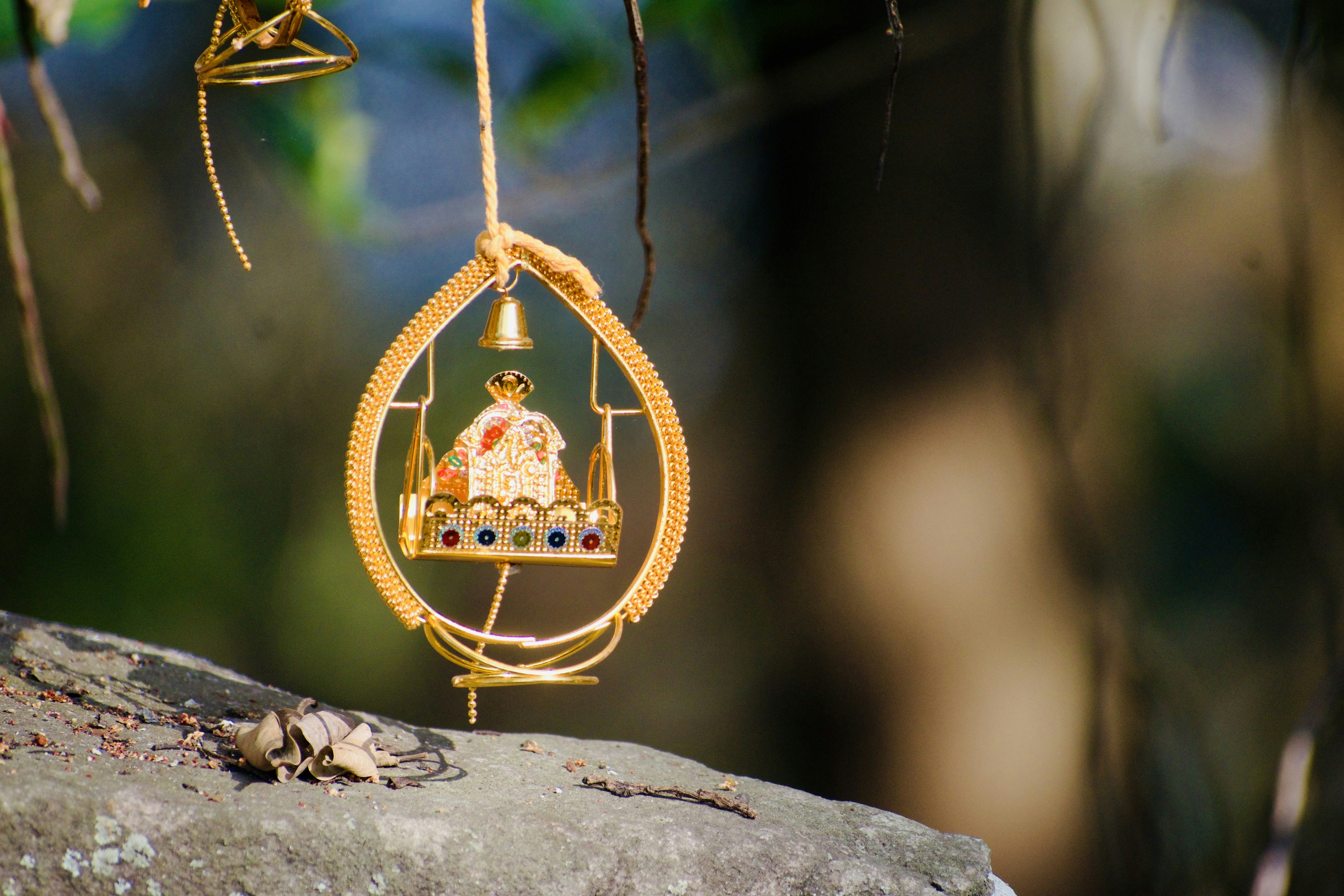 Golden pendant carousel suspended above weathered stone