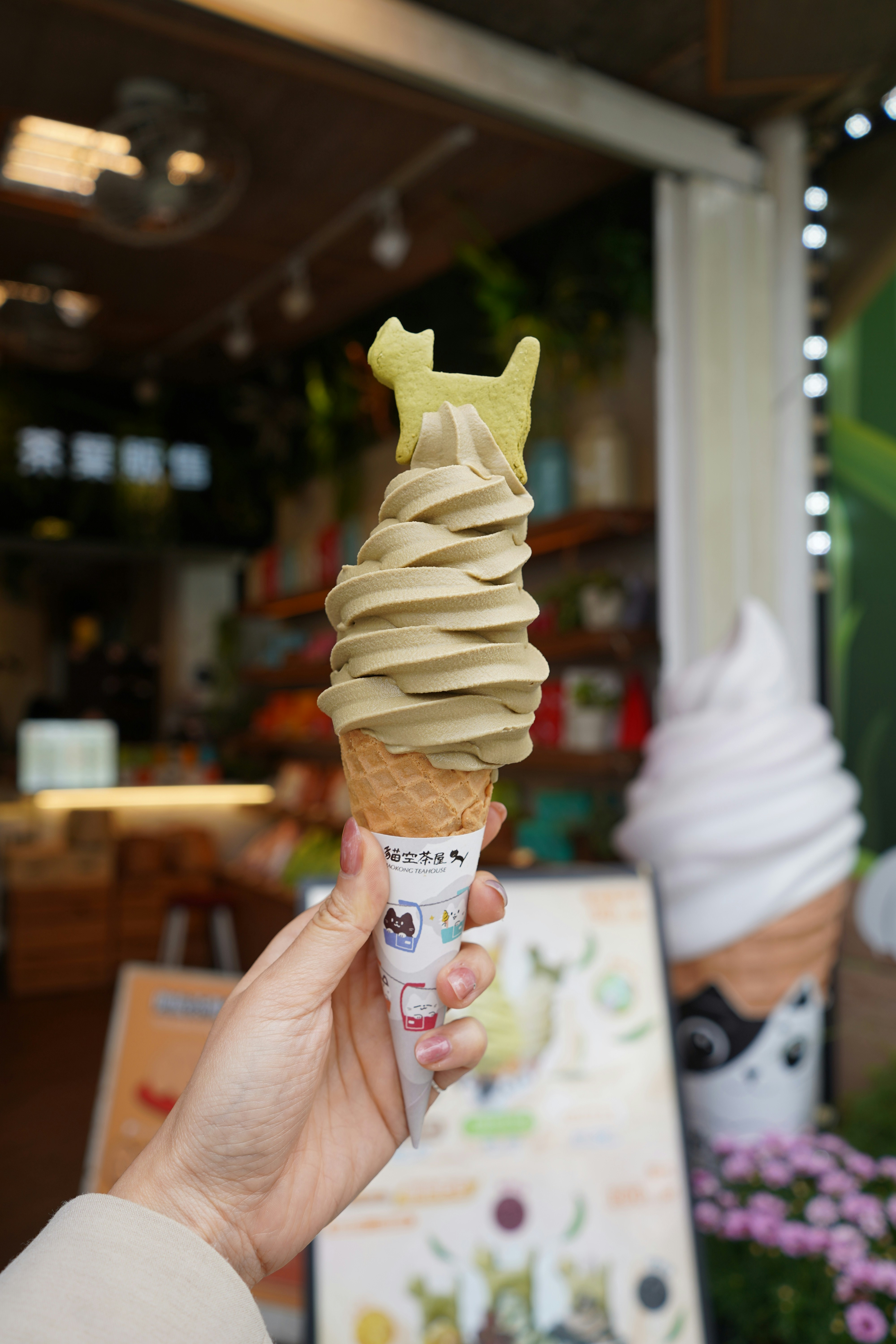 Cream-Swirled Cone in Focus, Against a Cozy Café Backdrop