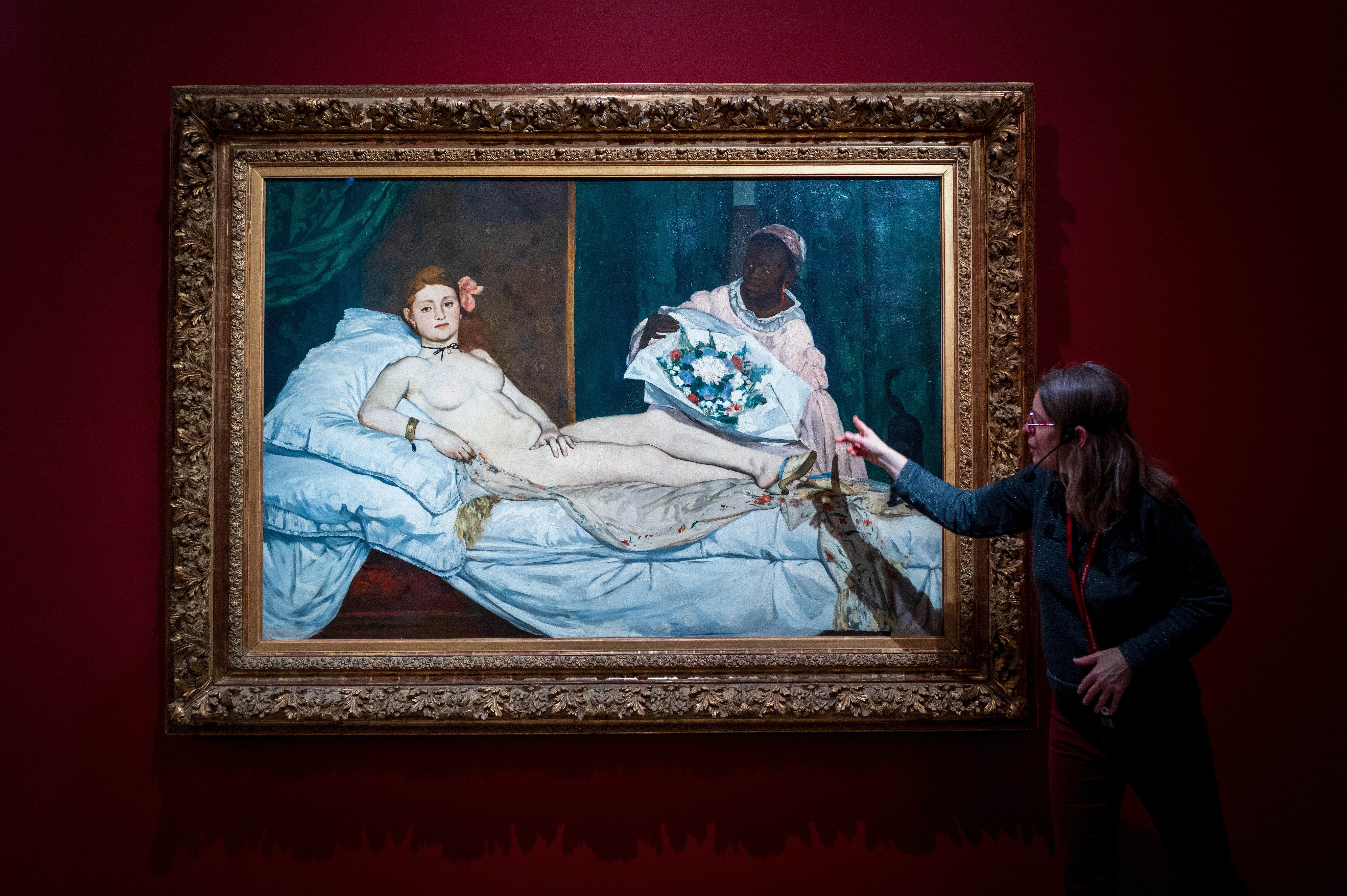 Crimson Gallery: A Reclining Nude Draws a Visitor's Gaze