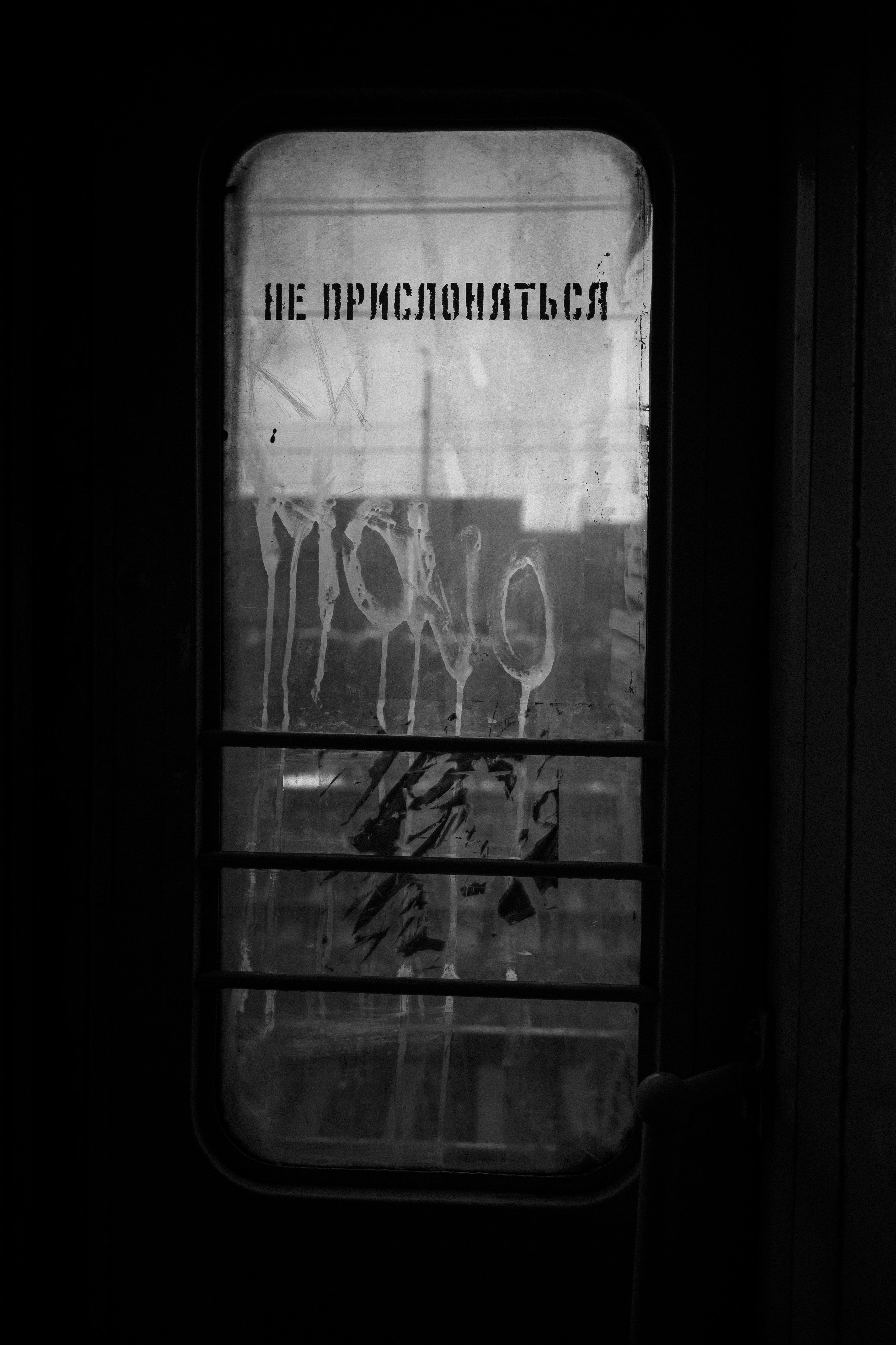 Frosted Window Graffiti in a Dim Transit Car