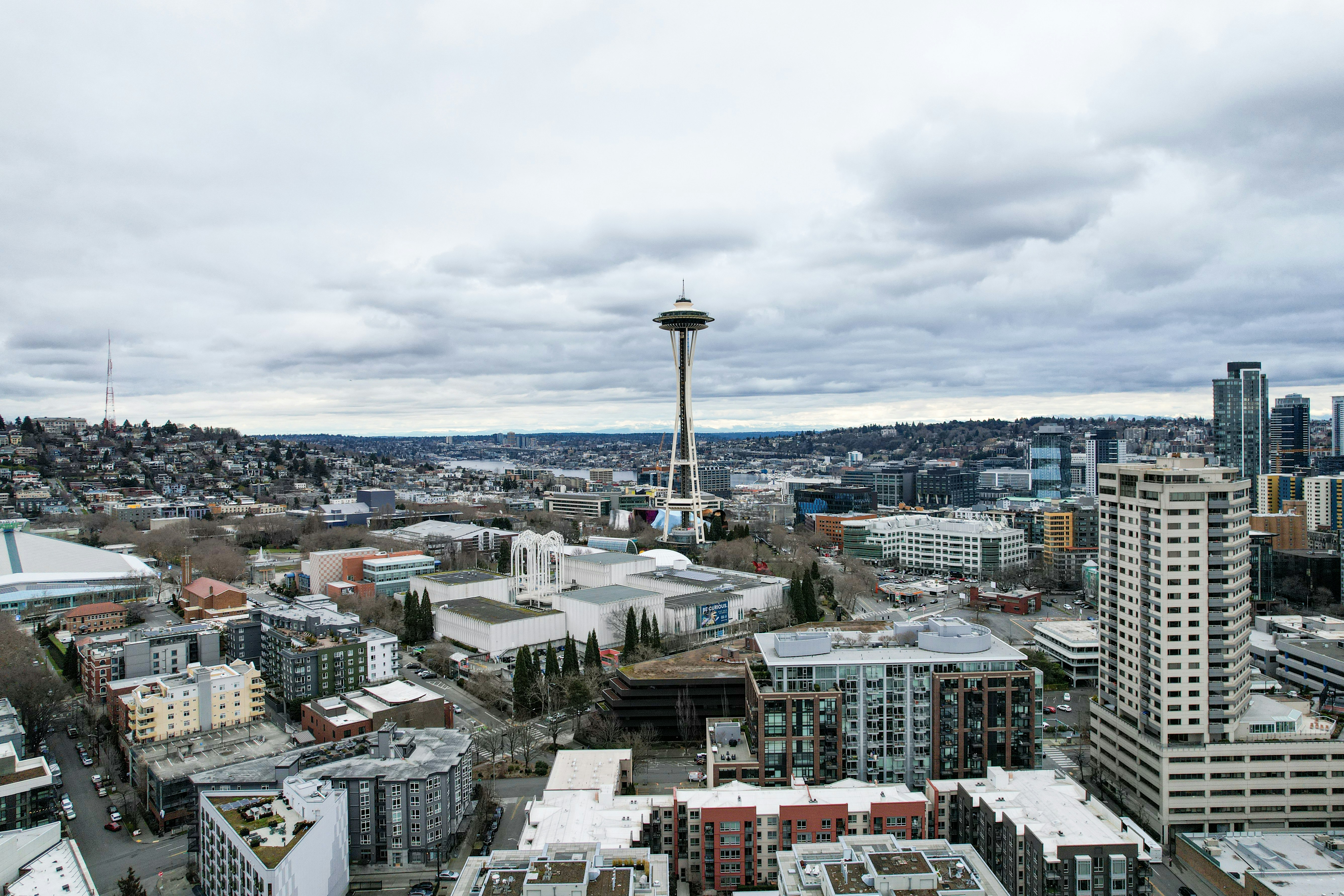 Seattle skyline with the Space Needle rising prominently under cloudy skies.