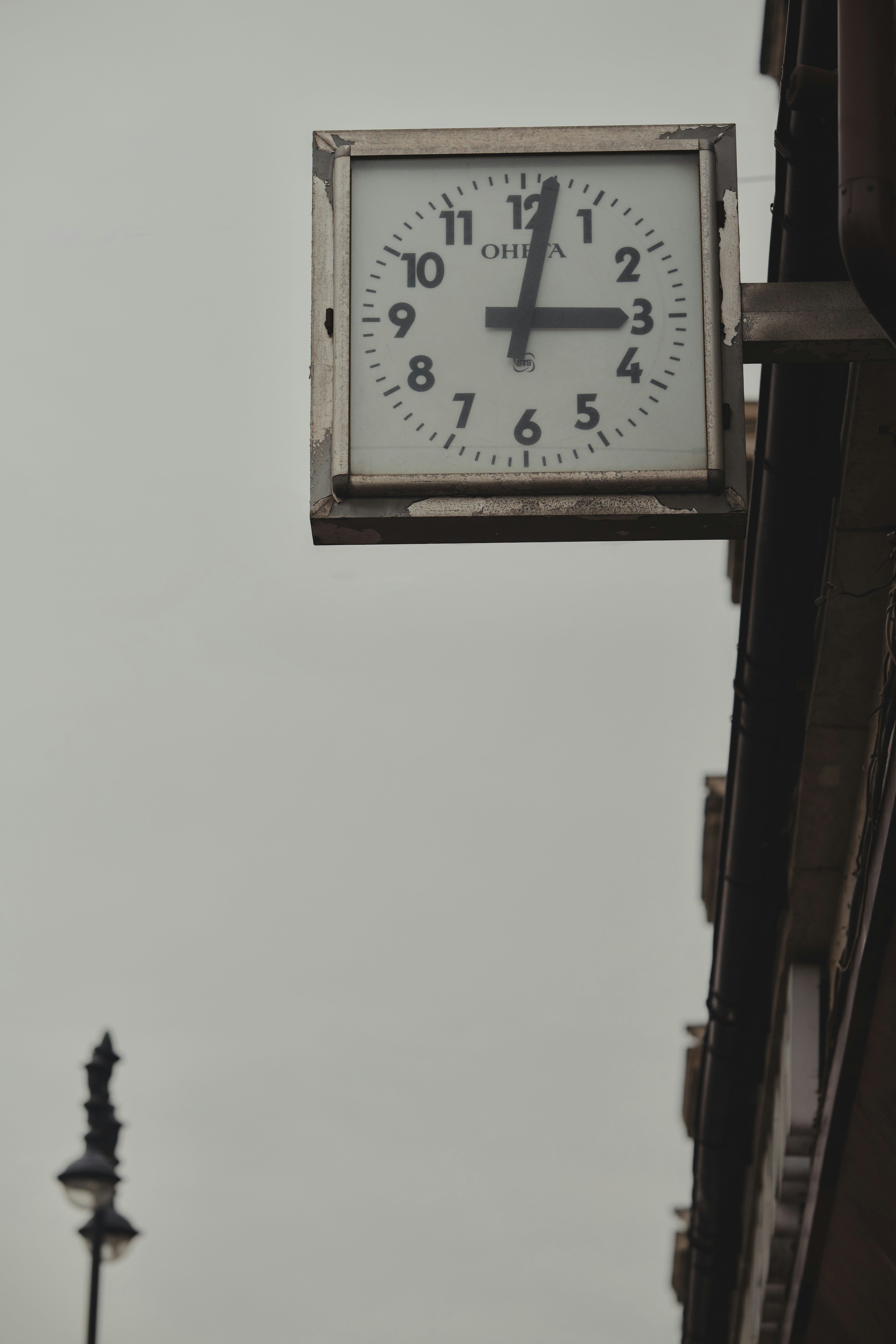 A clock is hanging on a building's exterior. photo – Free Clock Image ...