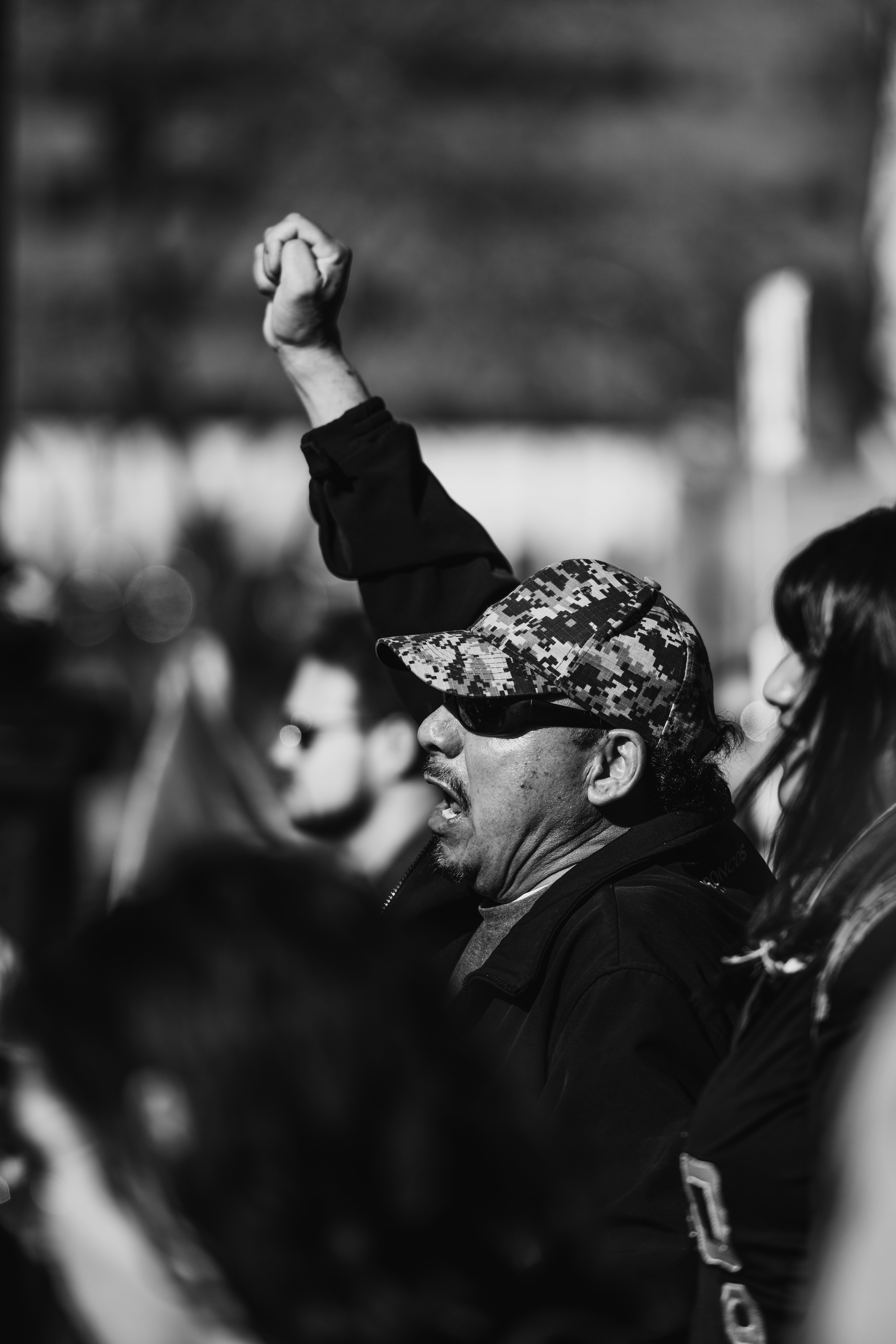 Raised Fist in Mono: A Crowd's Quiet Defiance