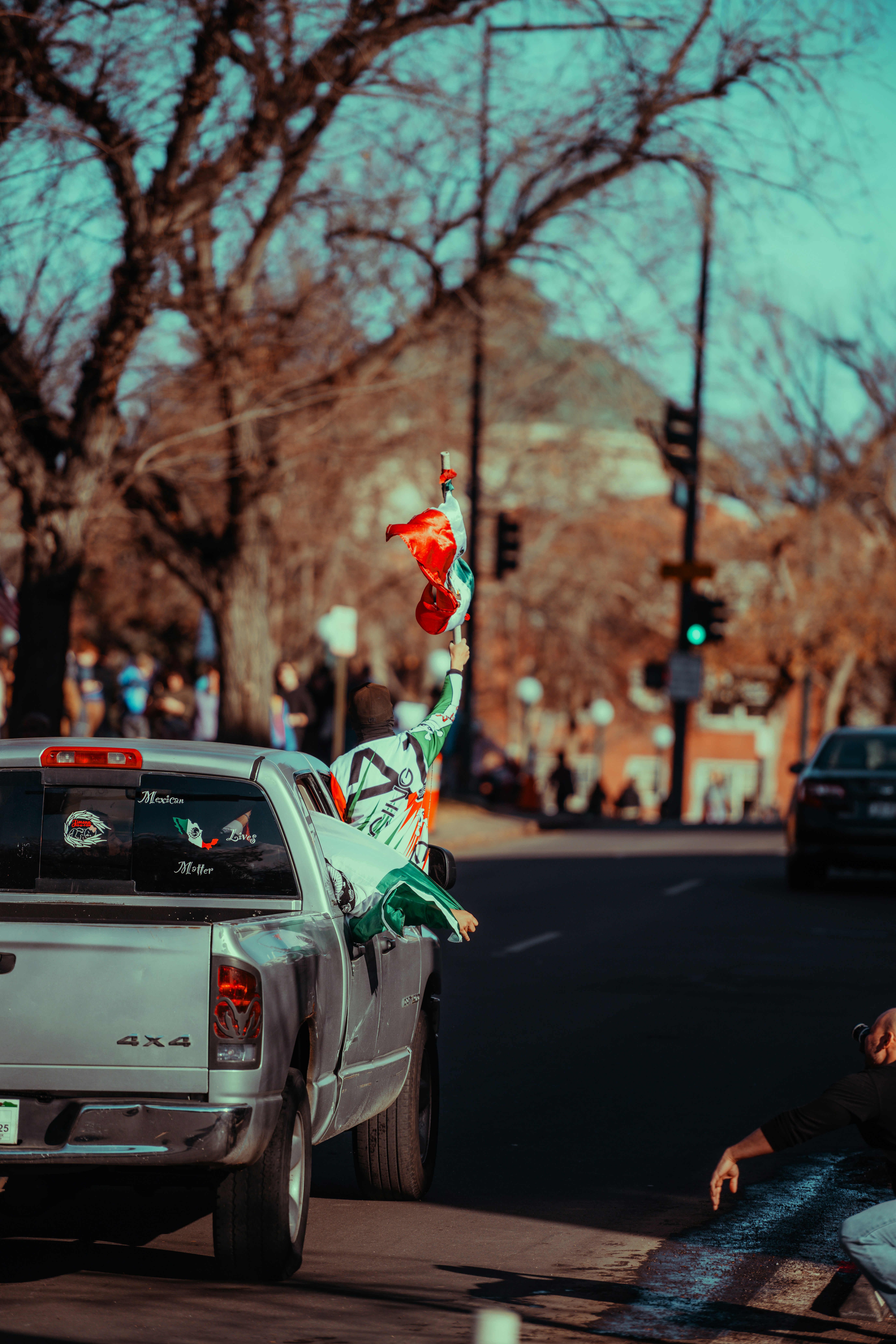 Flag-waving Rider Emerging from a Pickup in a Sunlit City Street