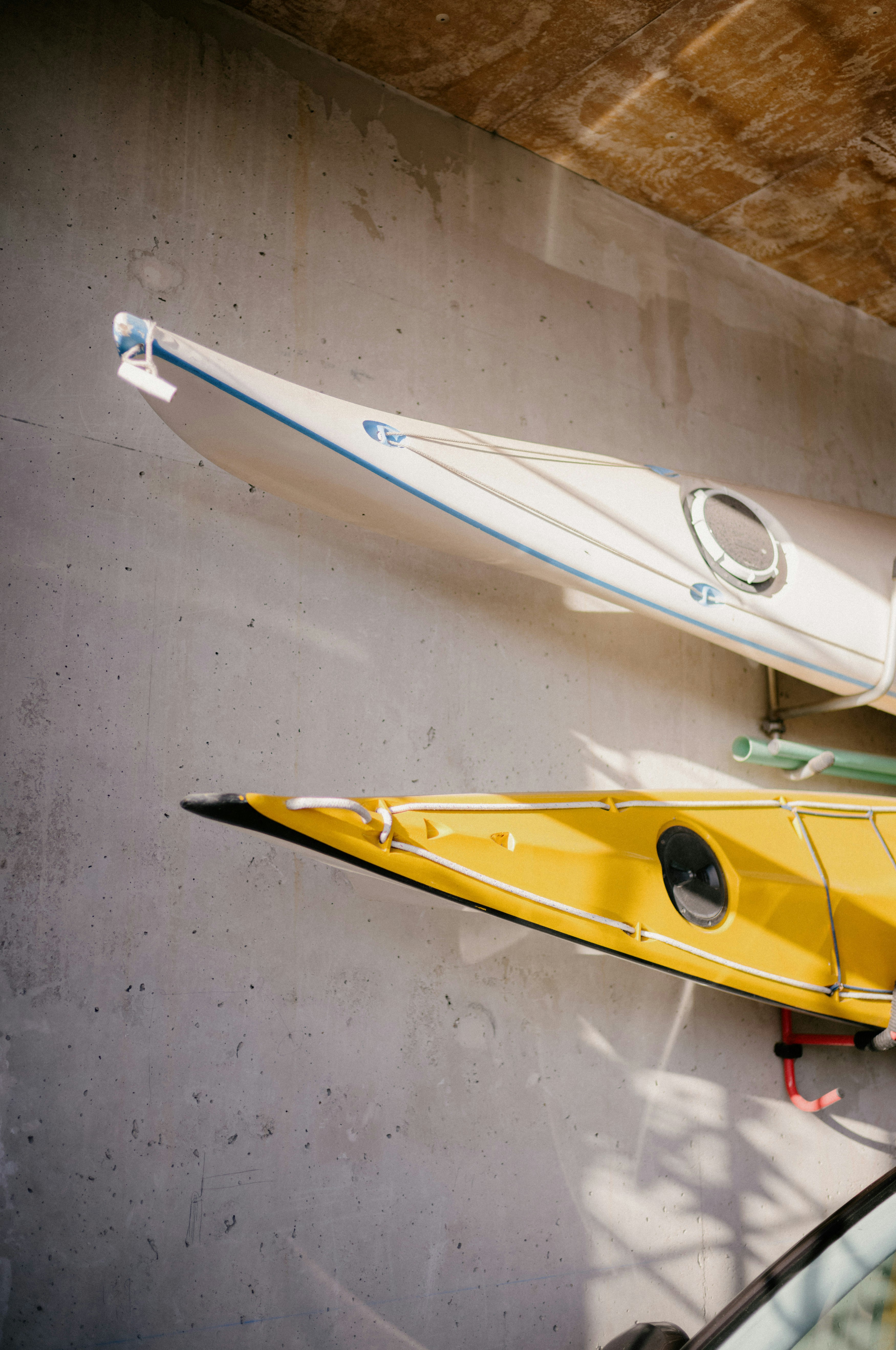 Two kayaks hang on a concrete wall. photo – Free Texture Image on Unsplash