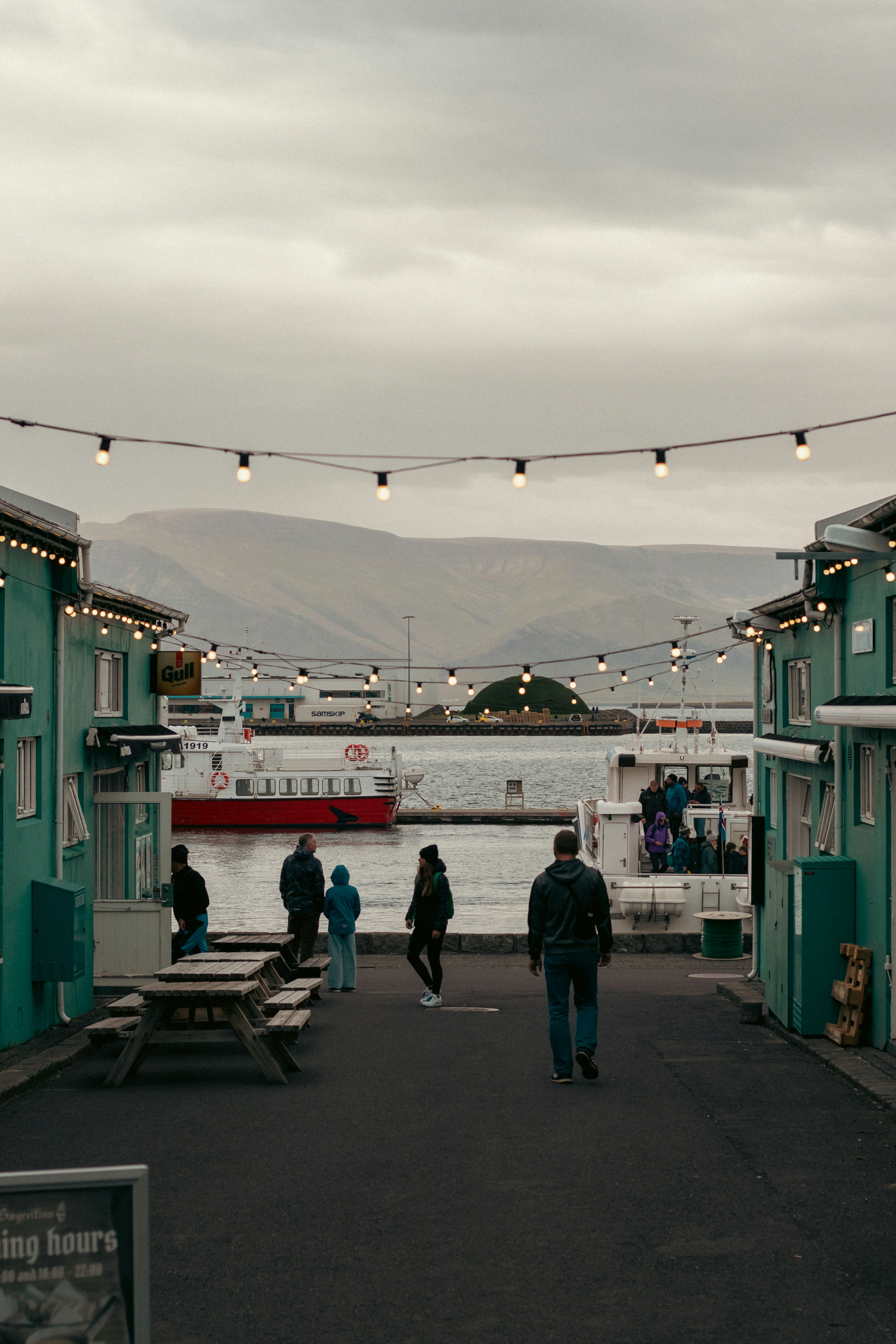 People stroll along a waterside pathway. photo – Free Portrait Image on ...