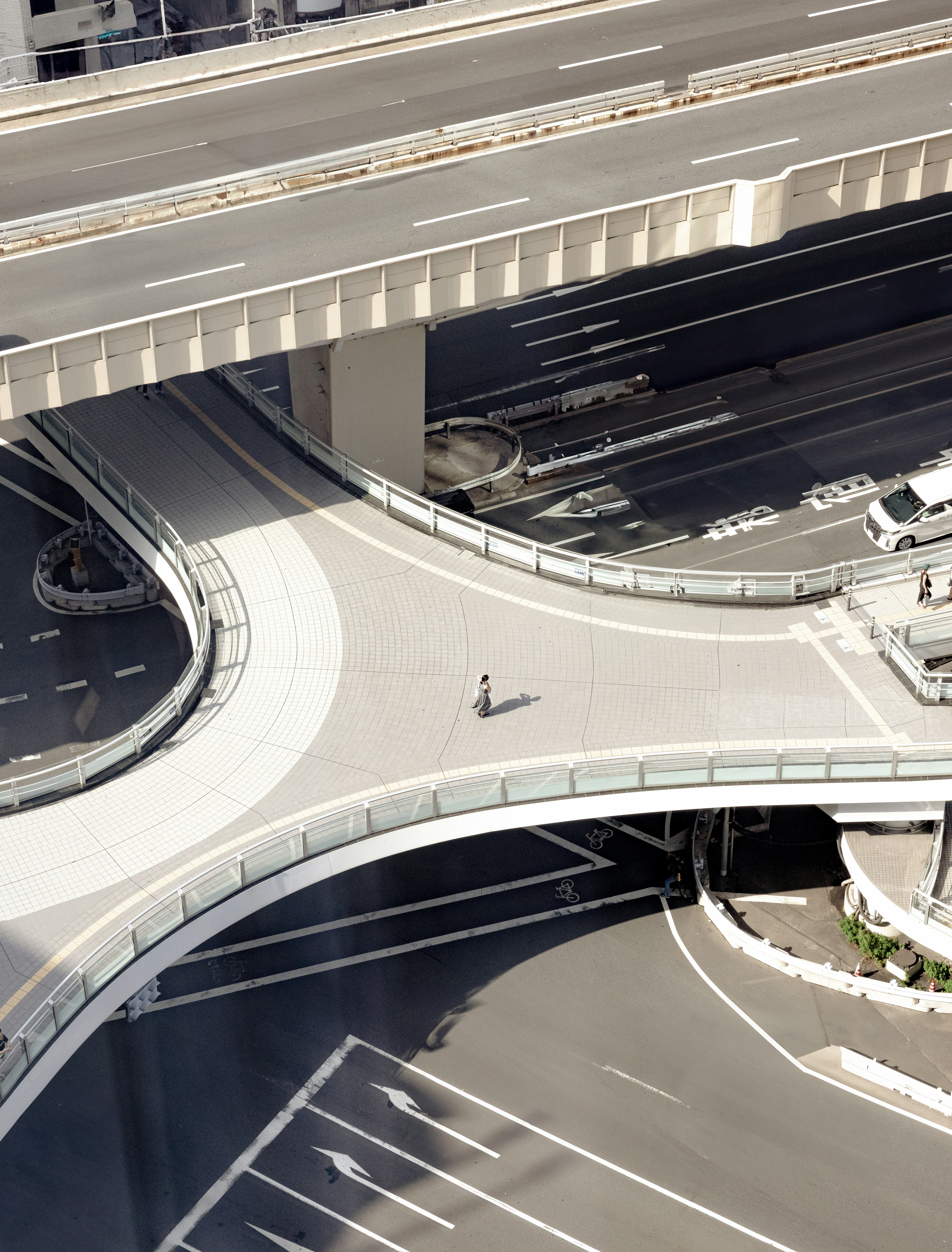 A pedestrian walks across a city overpass. photo – Free Human Image on ...