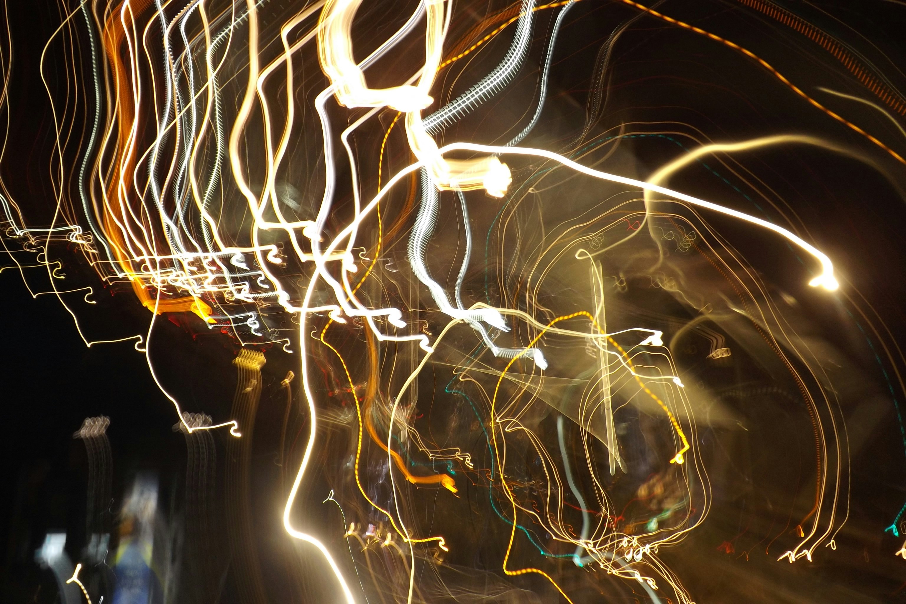 Abstract light trails create dynamic patterns against a dark background.