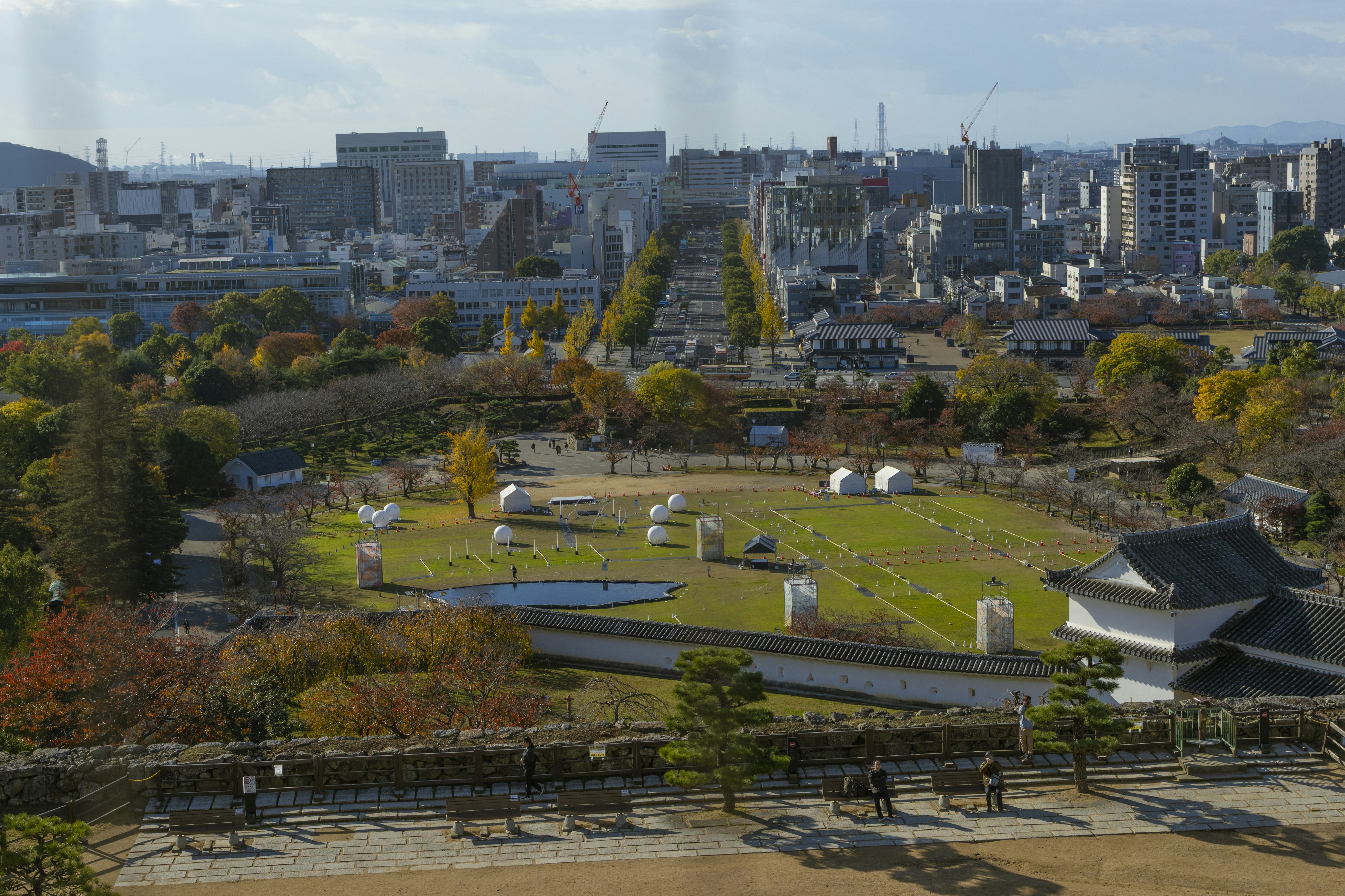 Cityscape with vibrant autumn foliage surrounding a historic park and modern skyline.