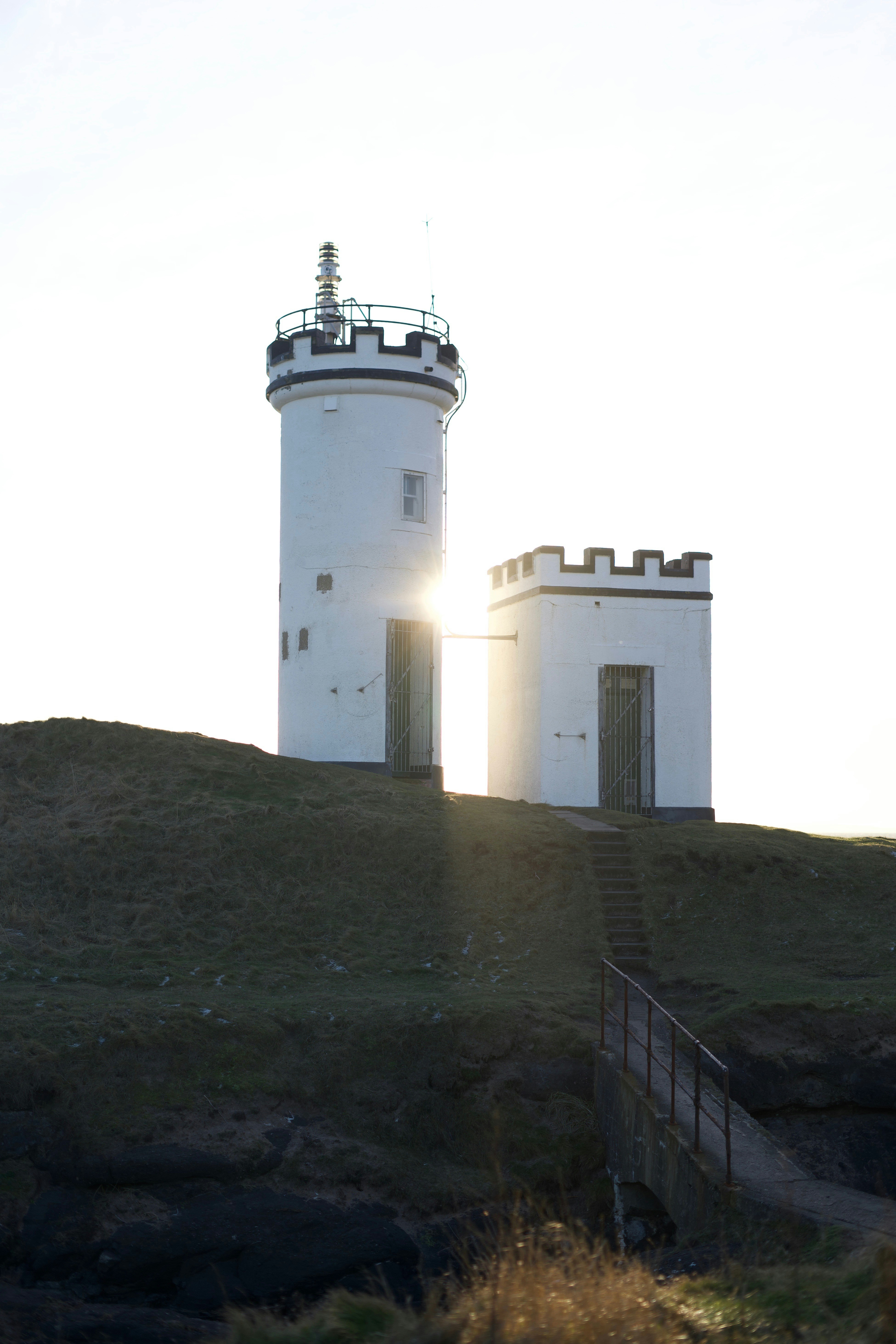 Sunburst Between Doors: A Hilltop Lighthouse