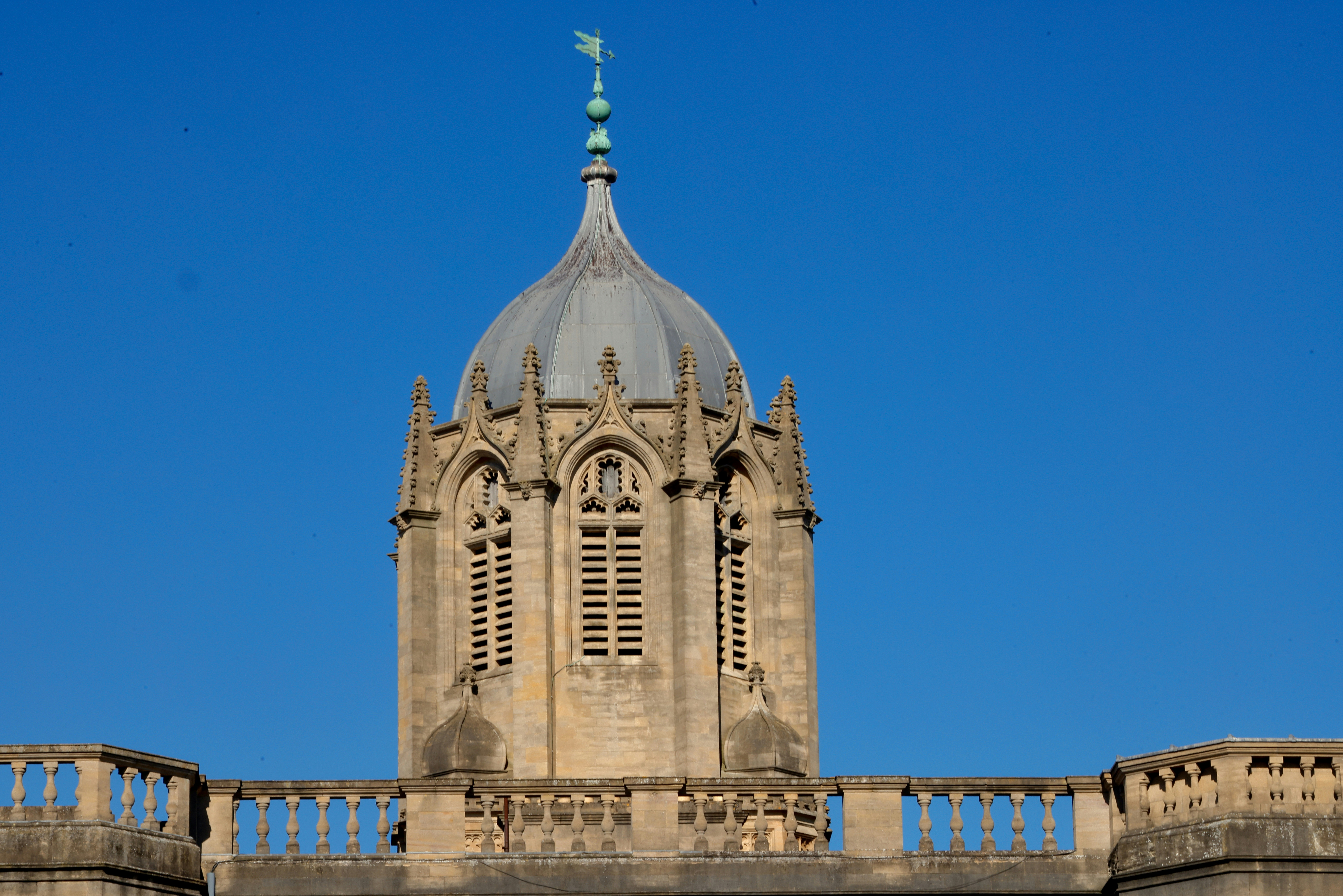 Gothic-style tower with intricate details set against a vibrant blue sky.