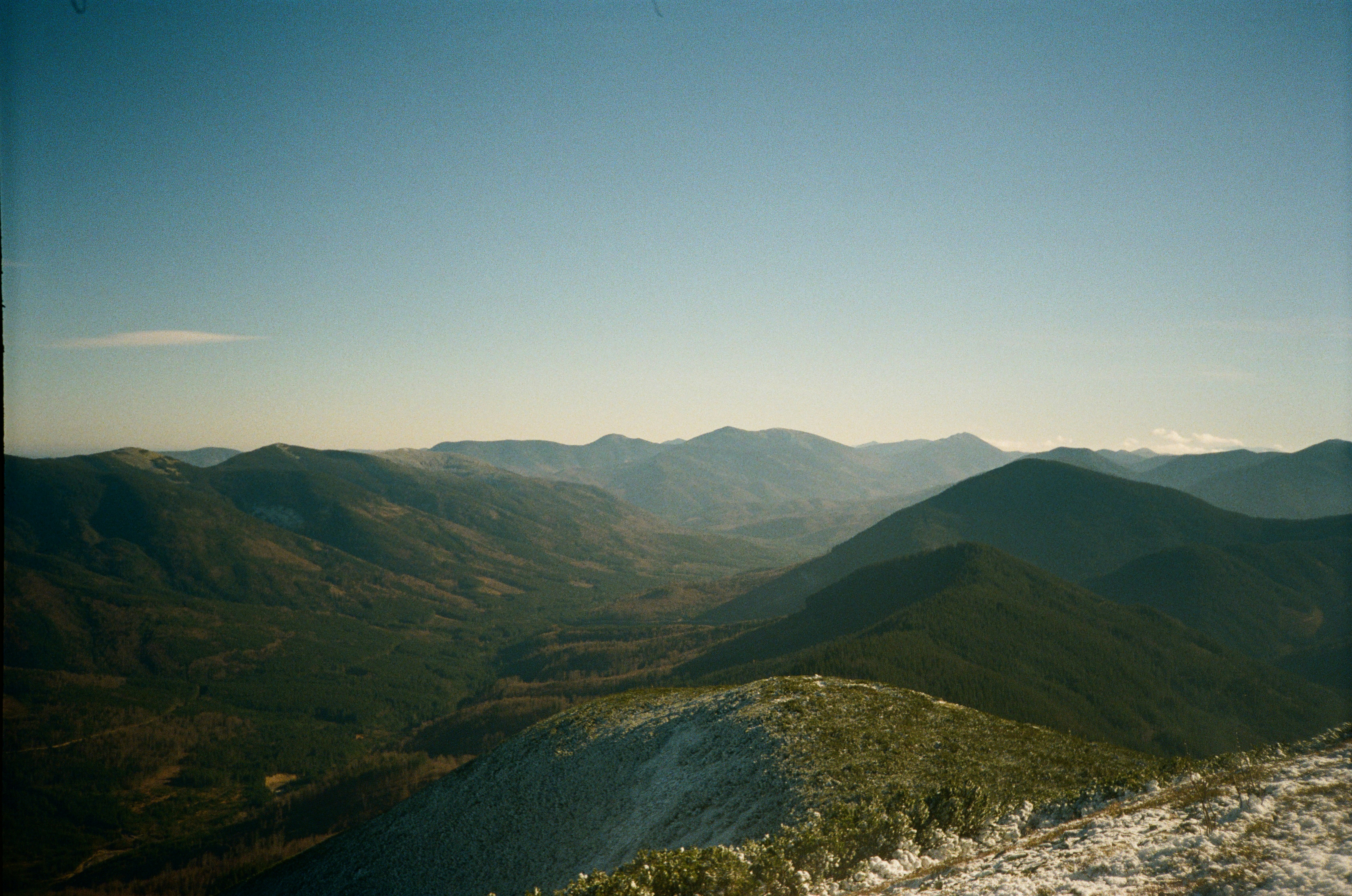 Snow-dusted mountain range under a clear blue sky.