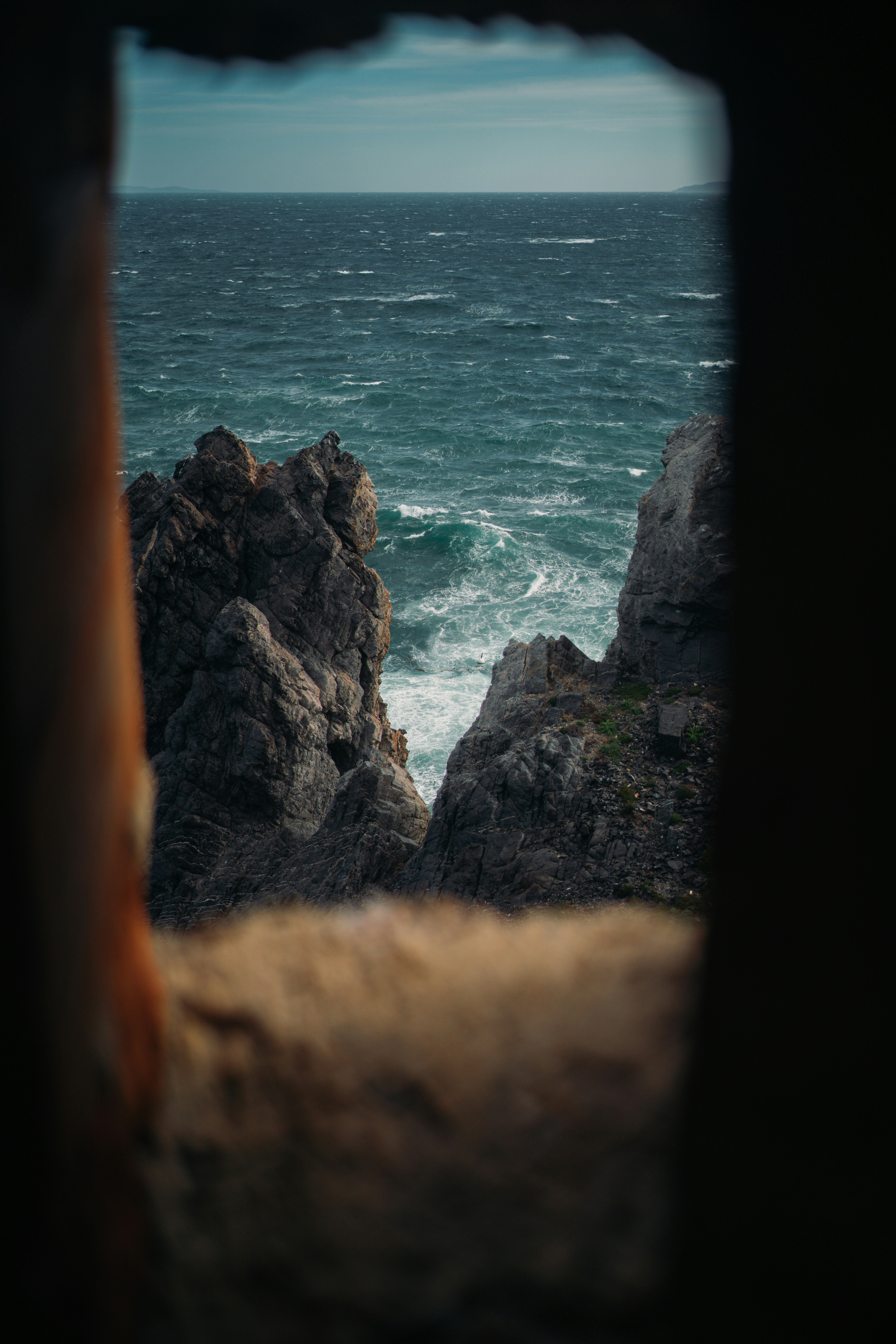 Ocean and rocky cliffs seen through an opening. photo – Free Wallpaper ...