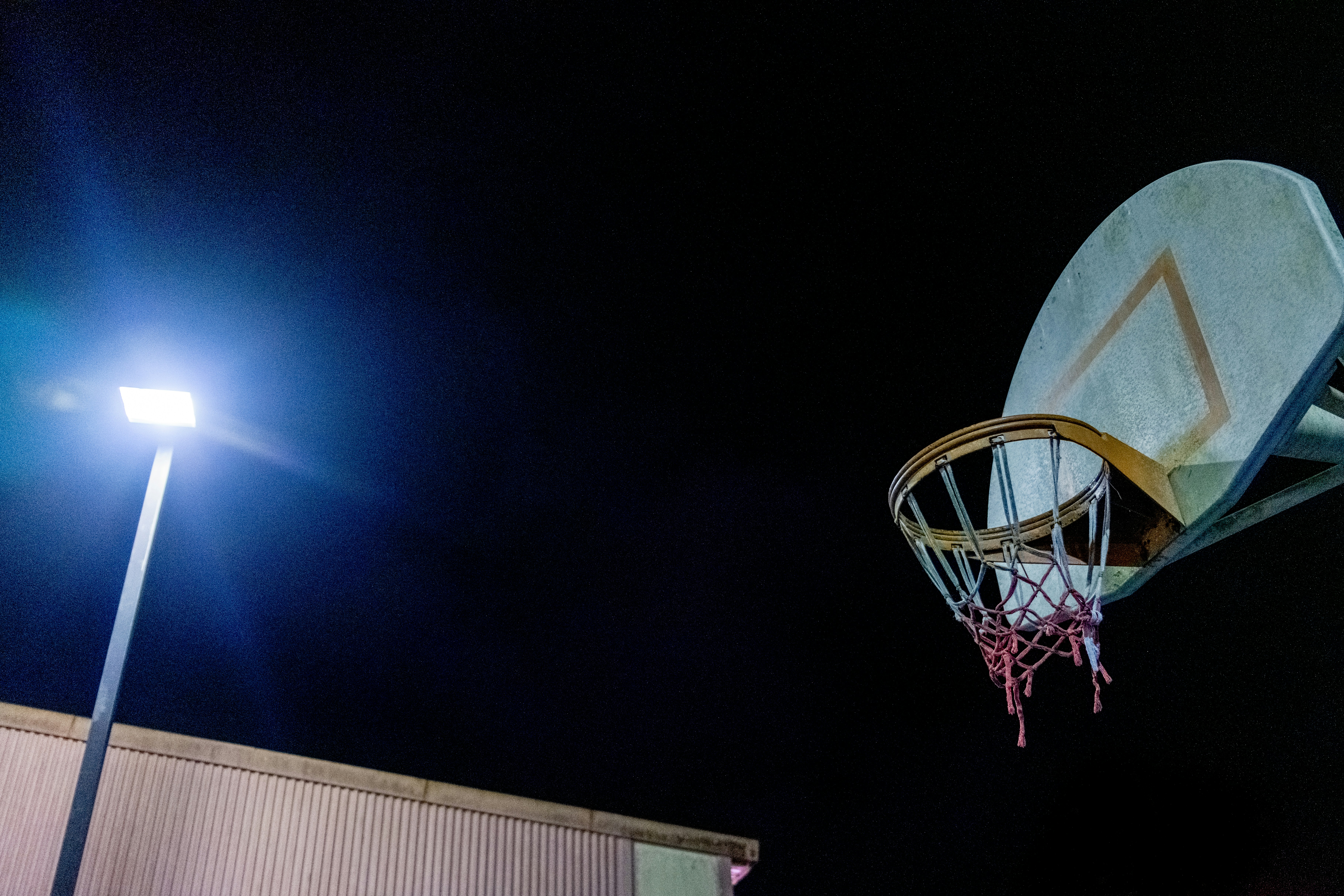 Basketball hoop lit by a bright street light at night. photo – Free ...