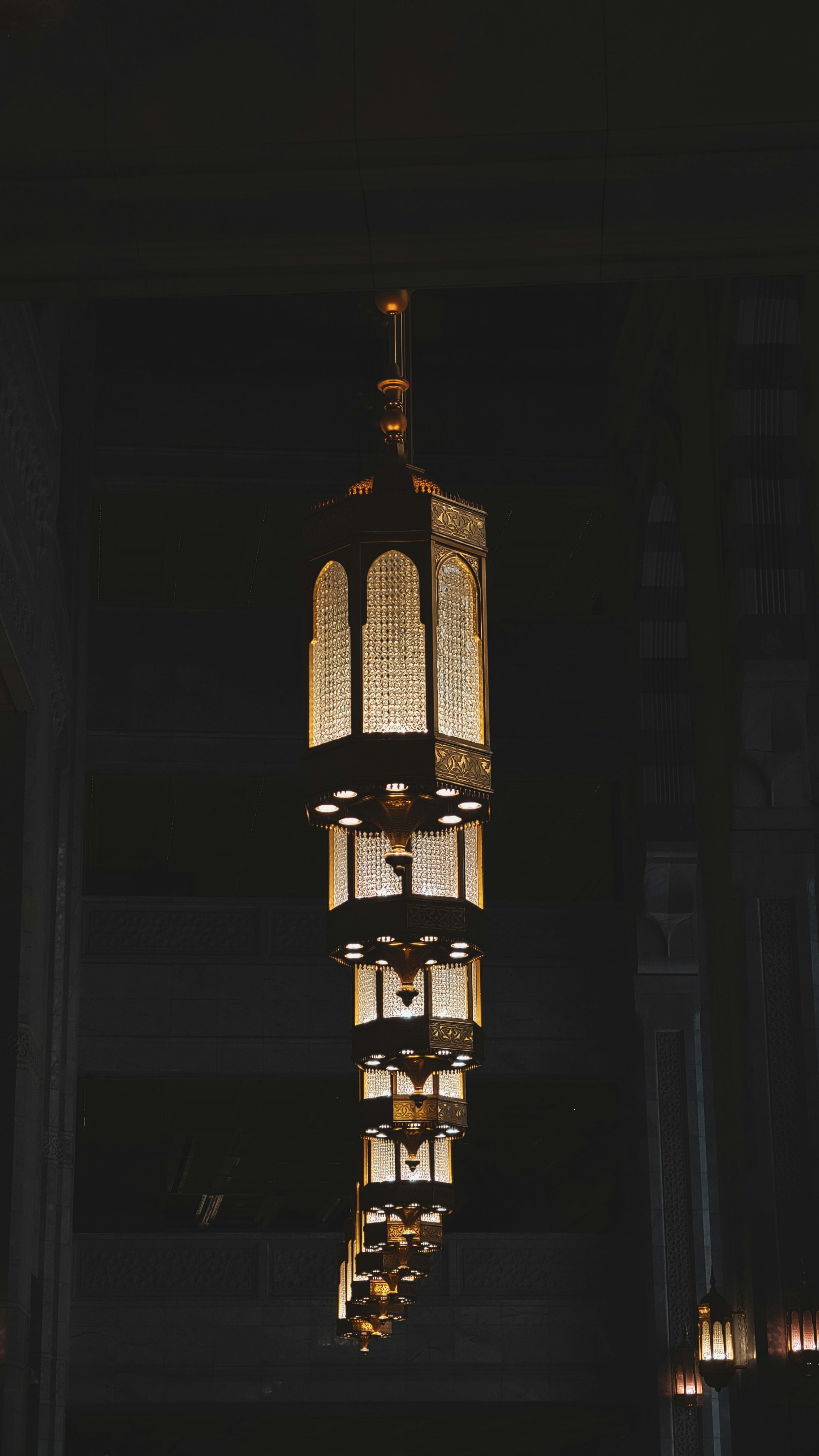 Beautiful, ornate lamps hanging from a dark ceiling.