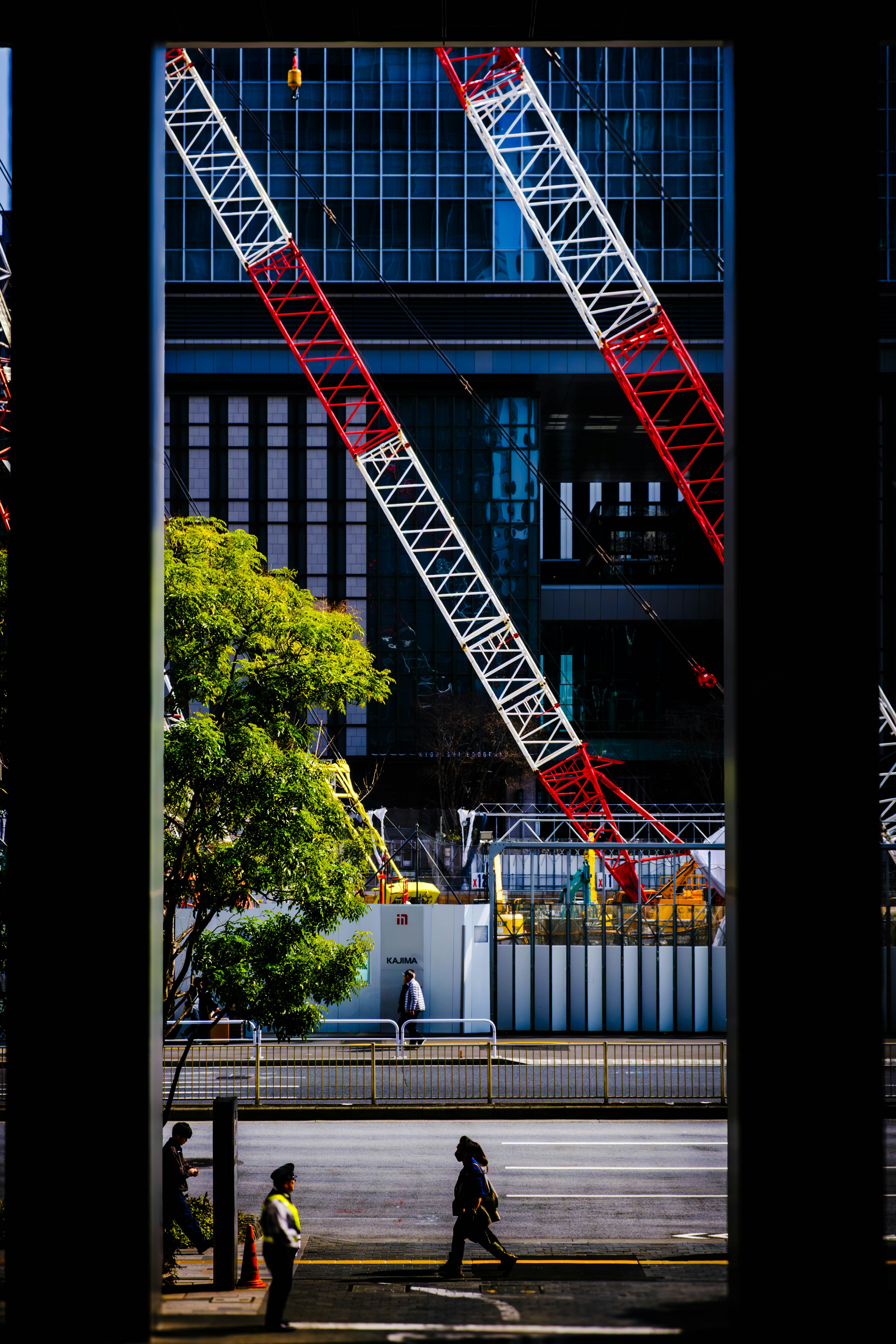Crisscrossing Cranes Framed by a Glass Skyline