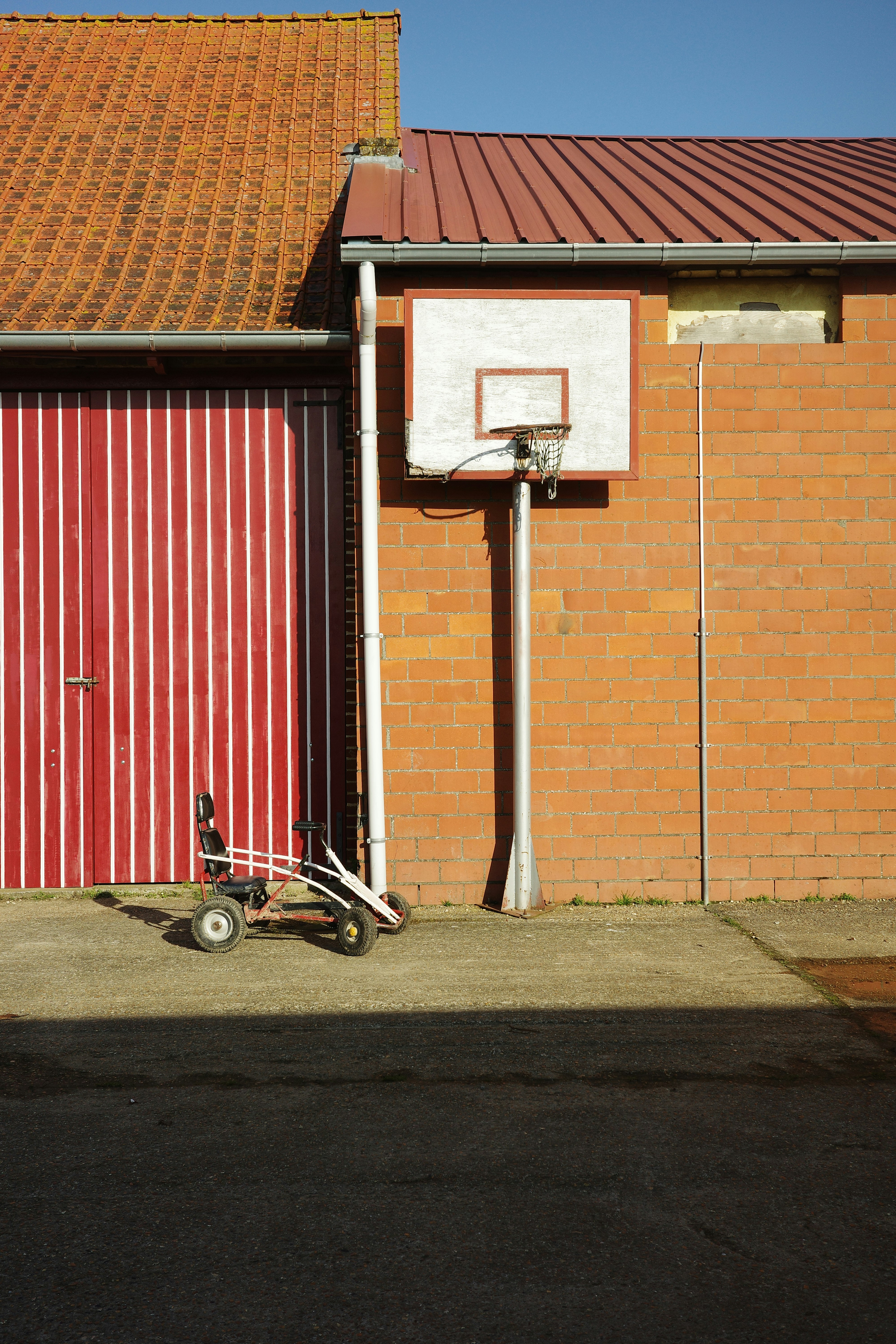 Sunlit Hoop Guarding a Quiet Brick Courtyard