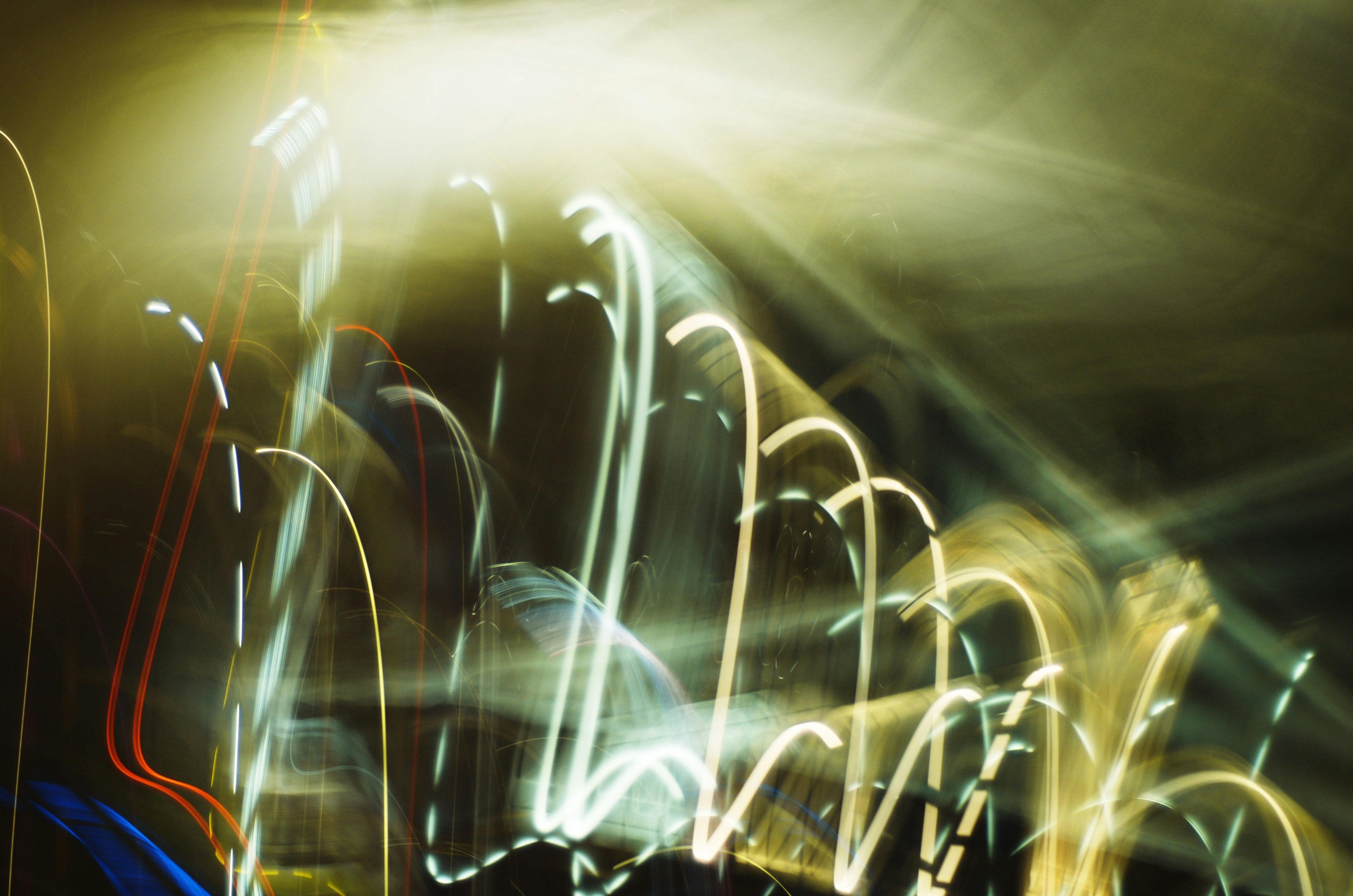 Abstract light trails in vibrant hues create a dynamic visual rhythm against a dark background.