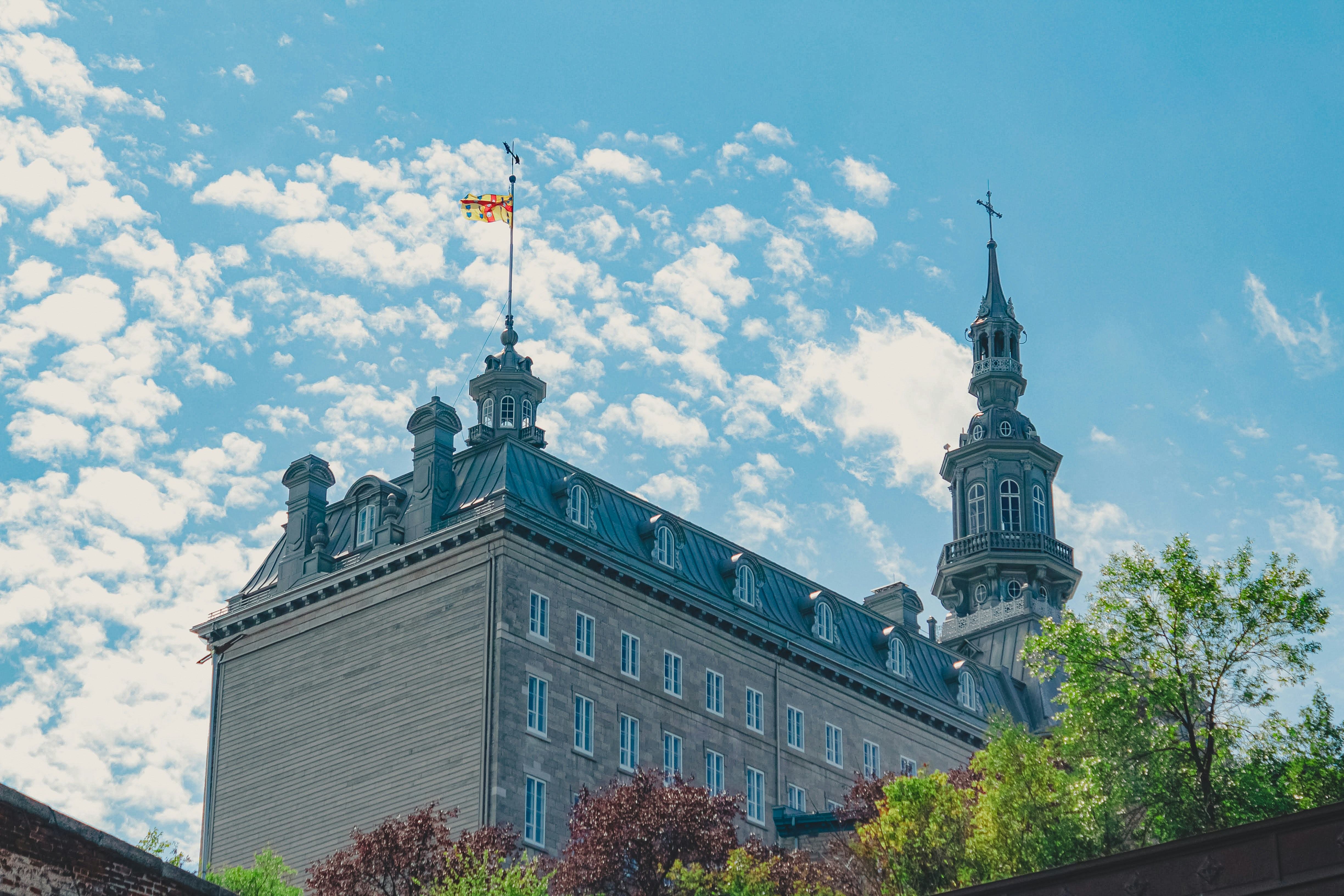Flag atop a Historic City Hall: A Spire Piercing the Cloudscape