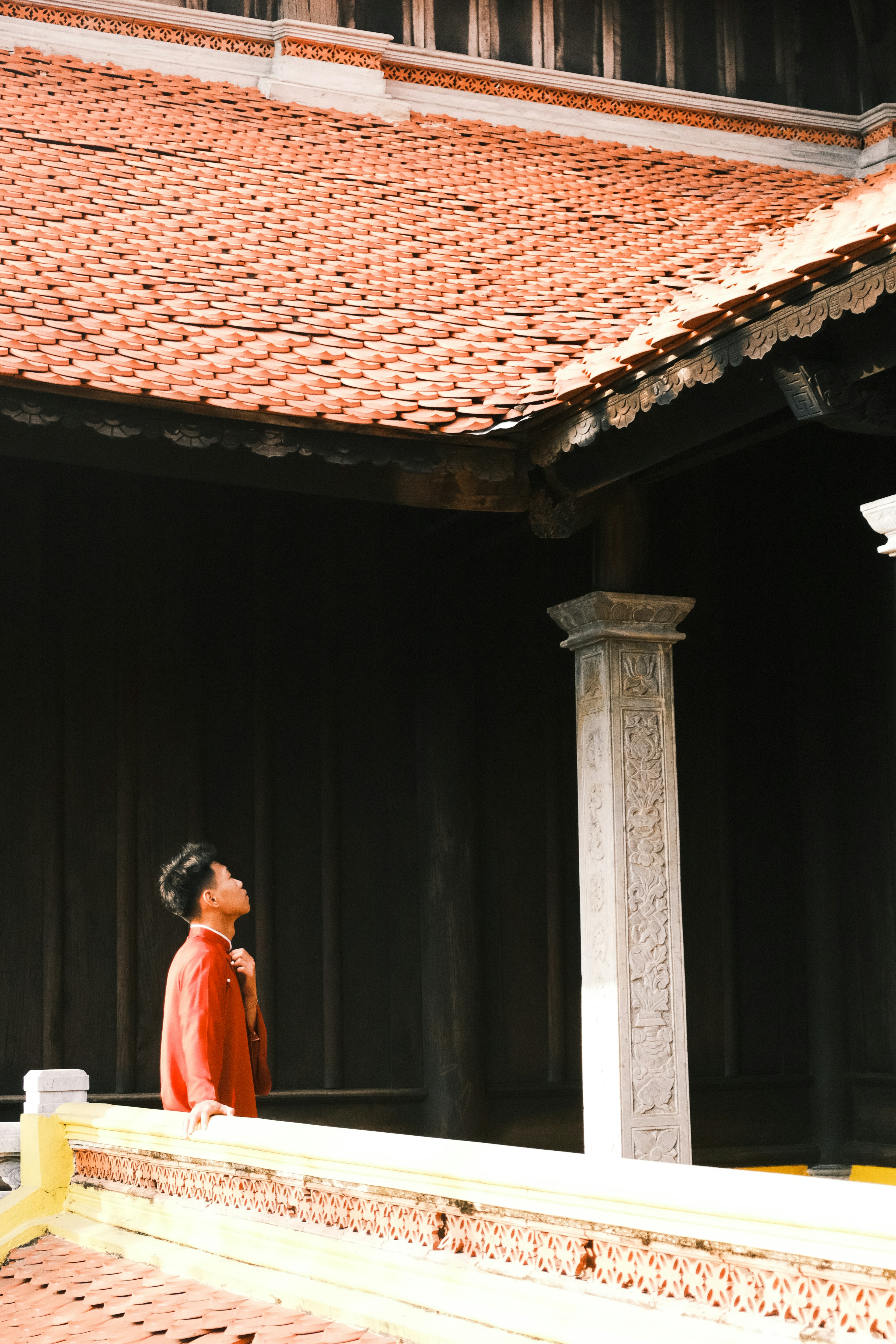 Crimson-Clad Figure on a Terracotta Balcony