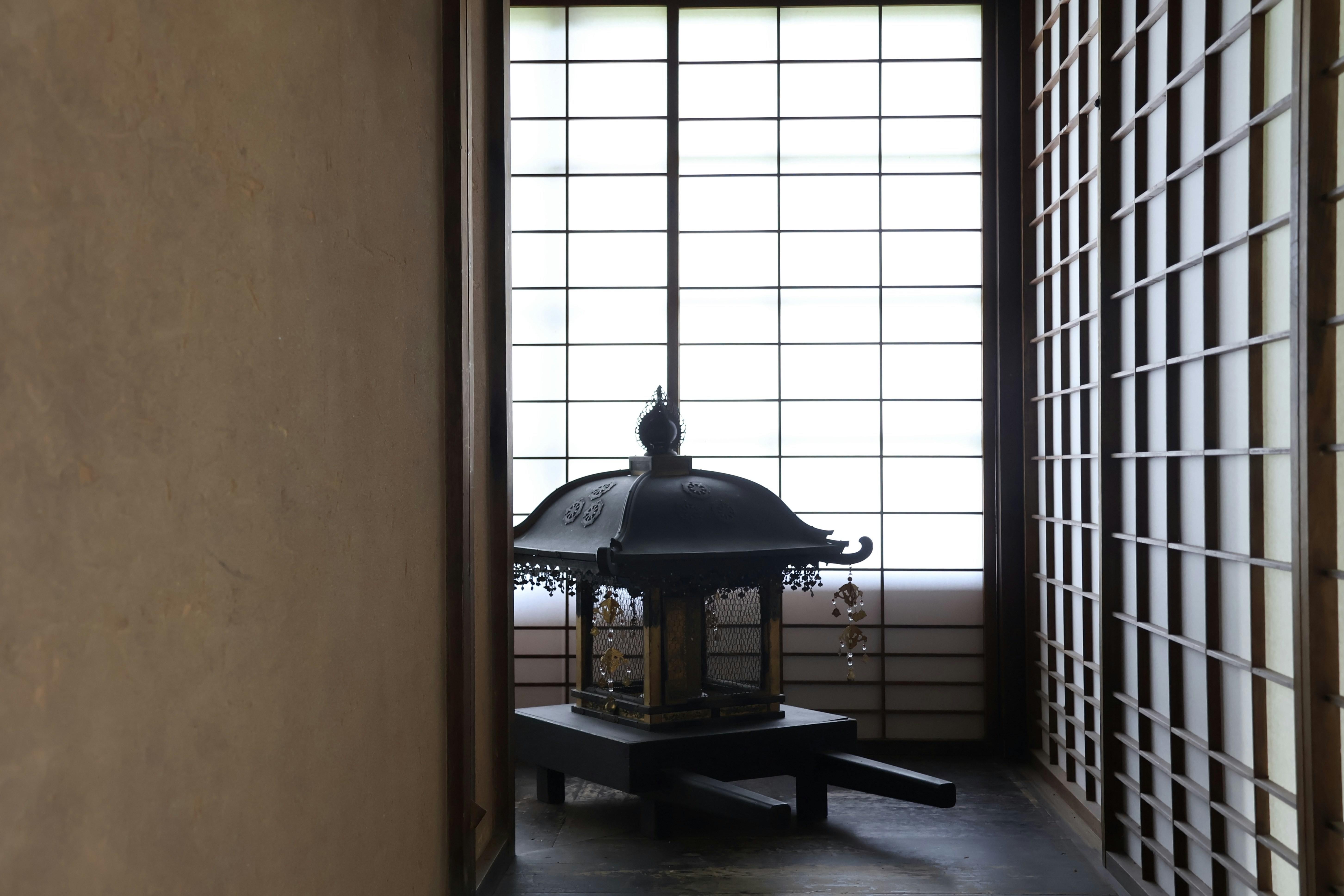Ornate lantern resting in a serene room with soft light filtering through shoji screens.