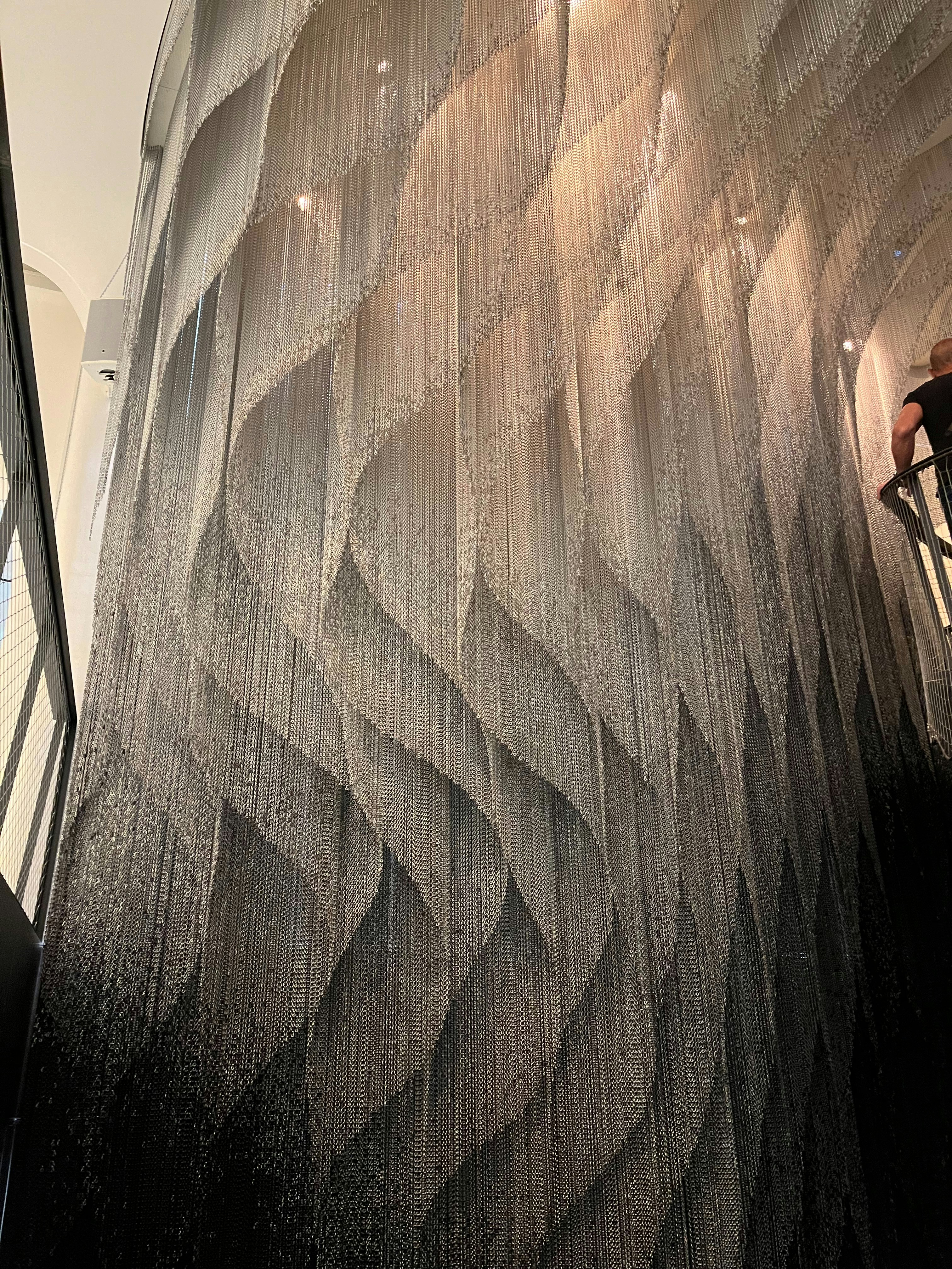 Cascade of textured, leaf-like panels enveloping a stairwell