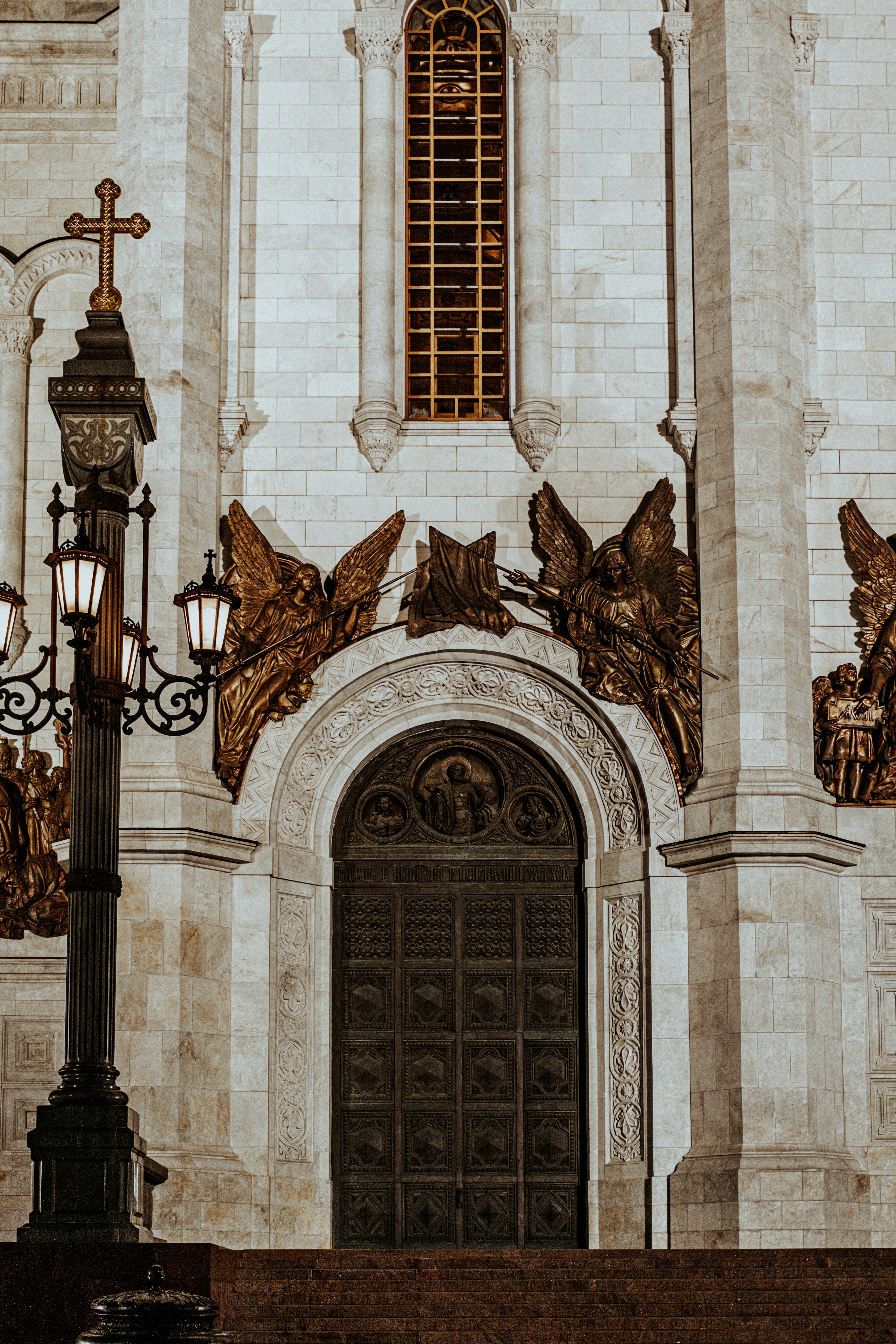 Golden Angelic Arch Framing a Marble Cathedral Door