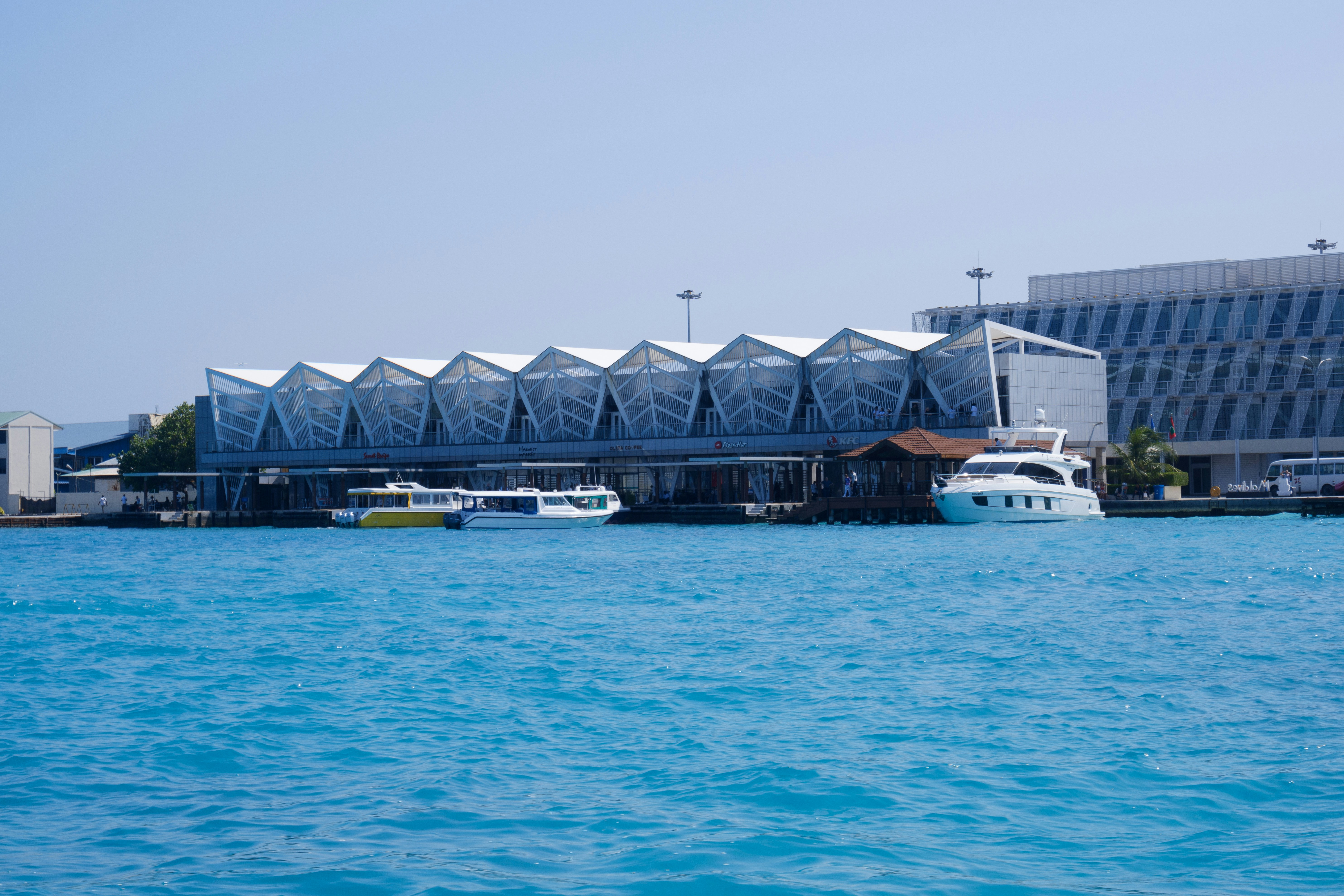 Boats docked at a modern harbor building. photo – Free Travel Image on ...