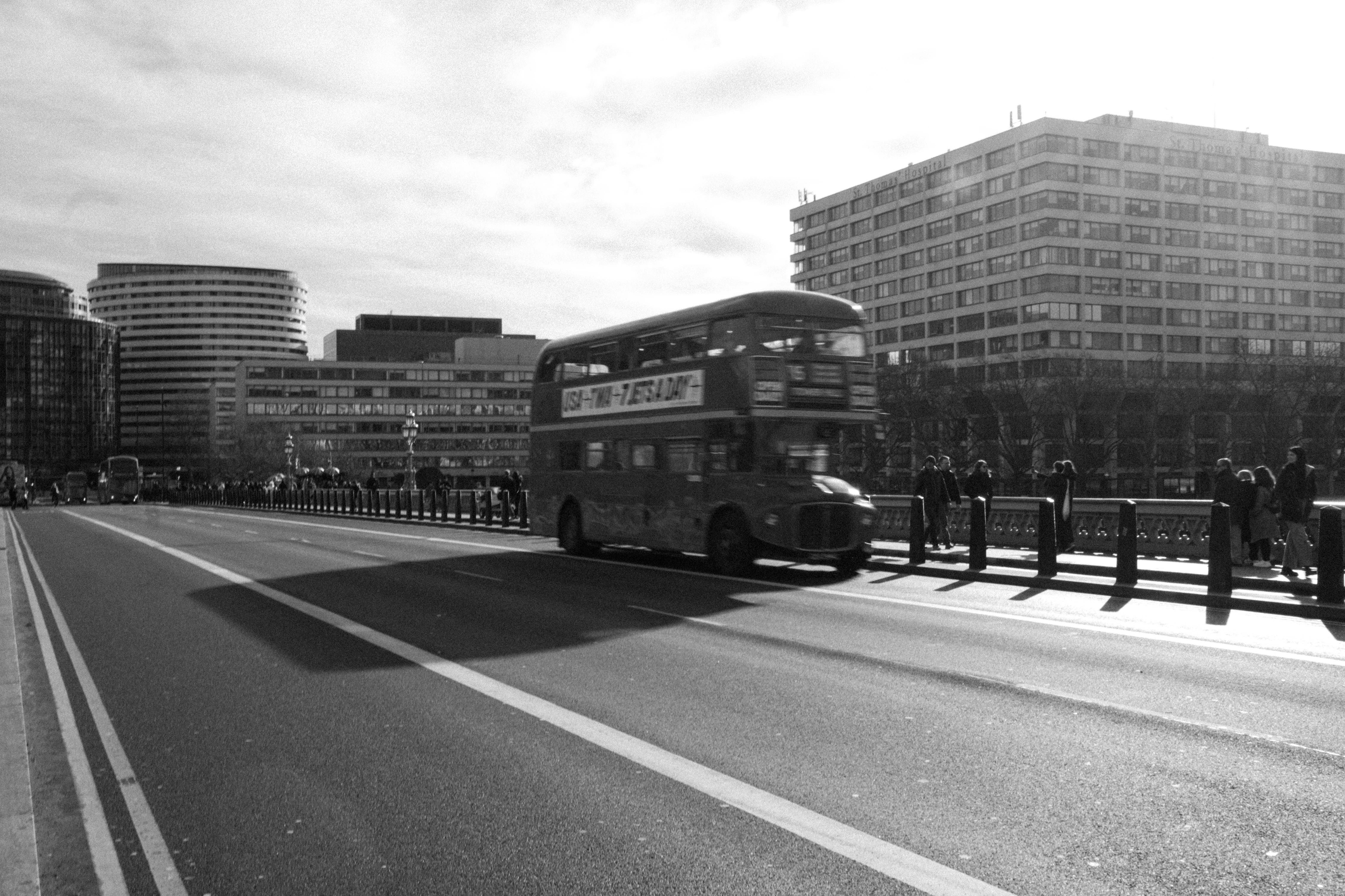 City Street in Motion: A Timeless Double-Decker Bus Crossing the Thames Bridge