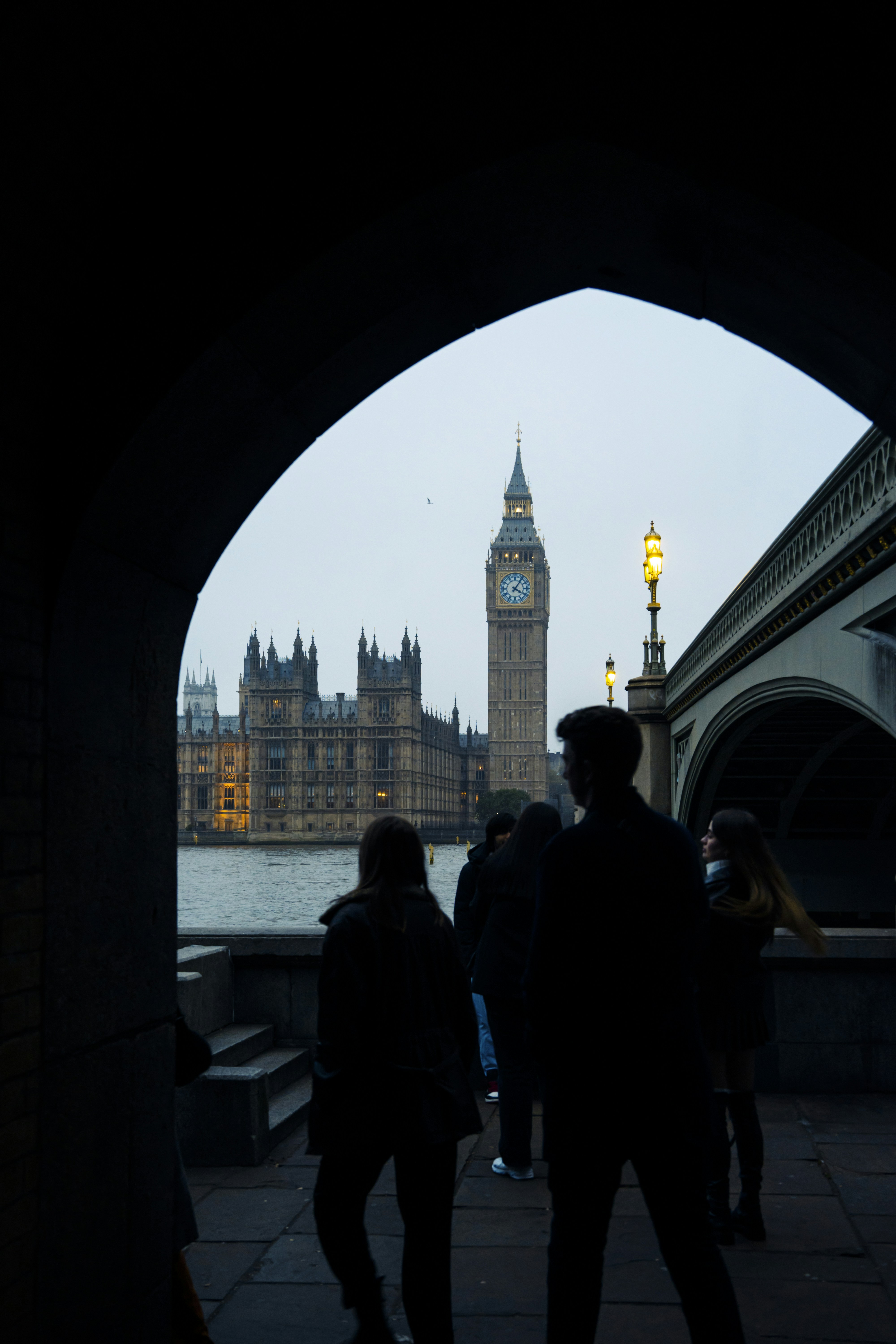 Shadowed silhouettes frame Big Ben from the arches