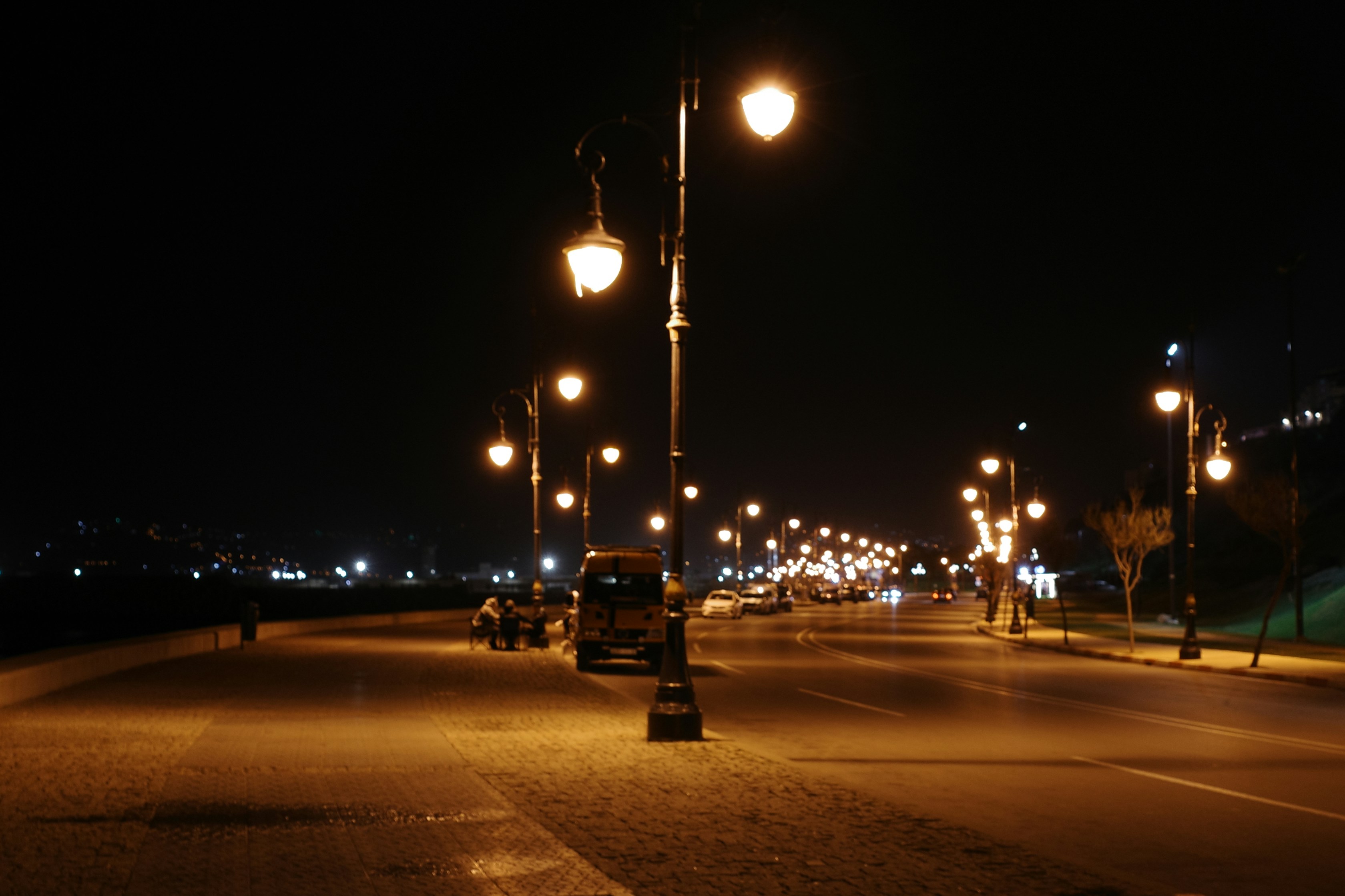 Amber Lanterns, Quiet Figures: Night Along the Seafront Promenade