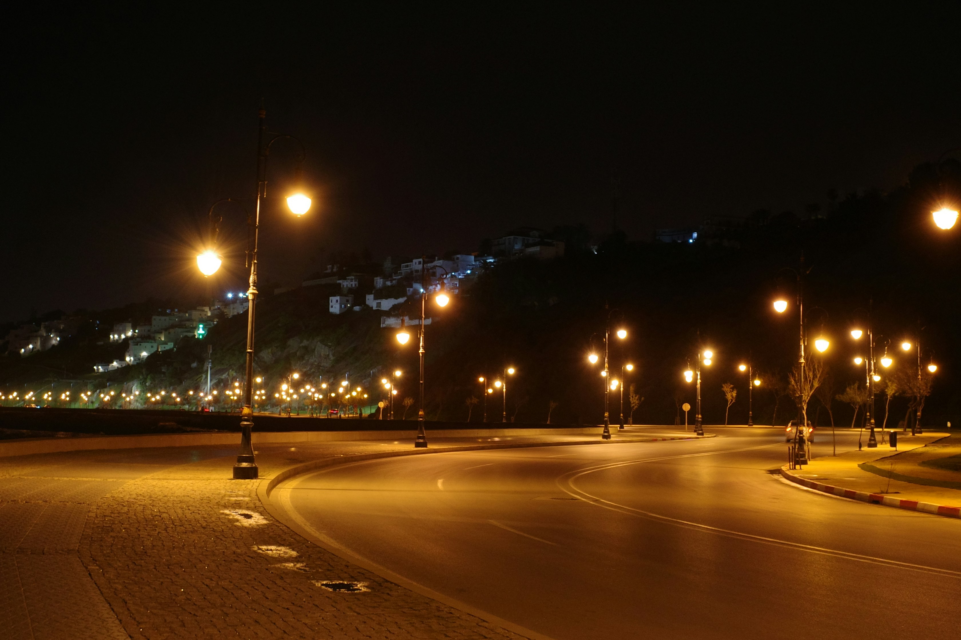 A road illuminated by street lights at night. photo – Free Car Image on ...