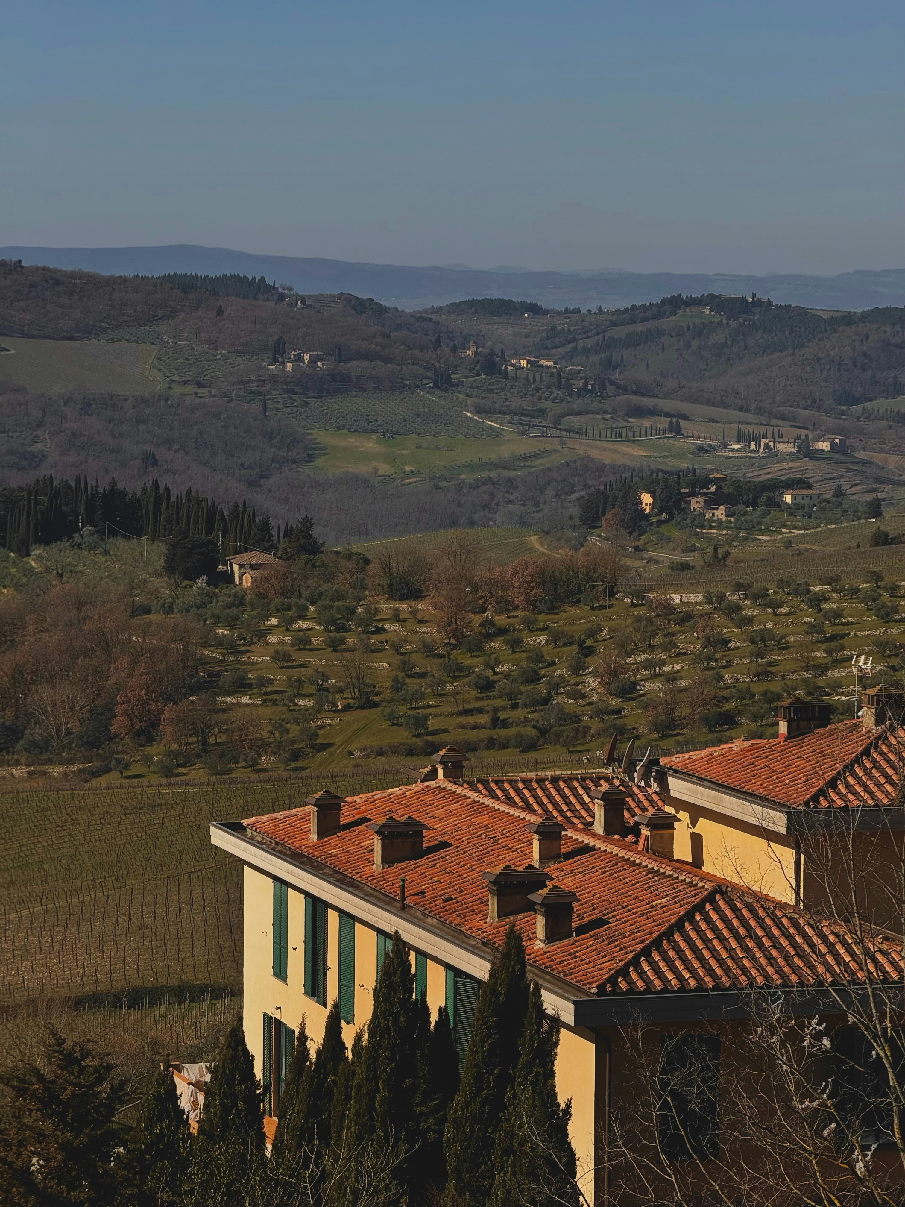 Rolling hills and houses dot a scenic landscape. photo – Free Building Image on Unsplash